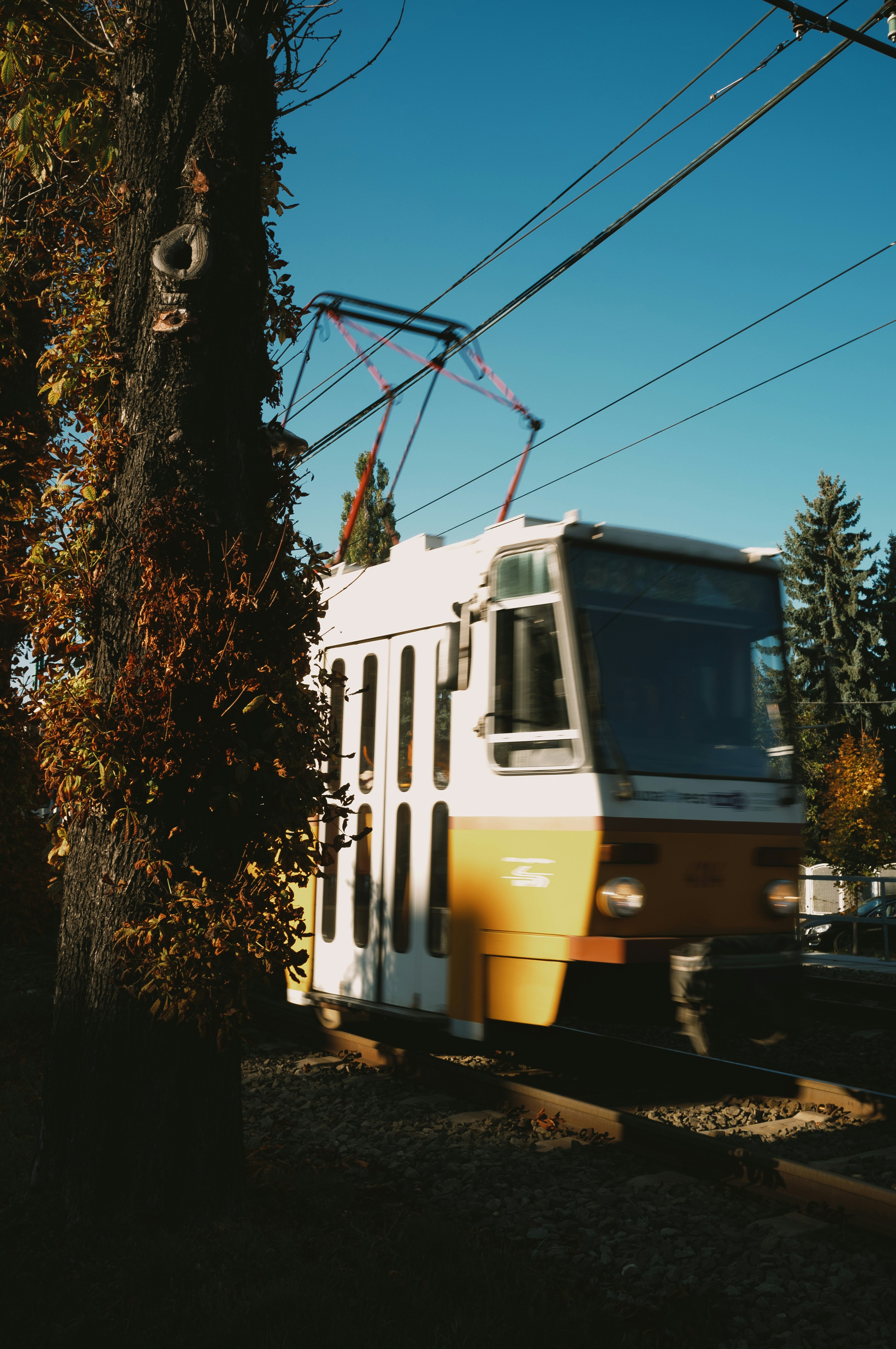 Yellow on Rails under a Cerulean Sky: A Tram in Motion