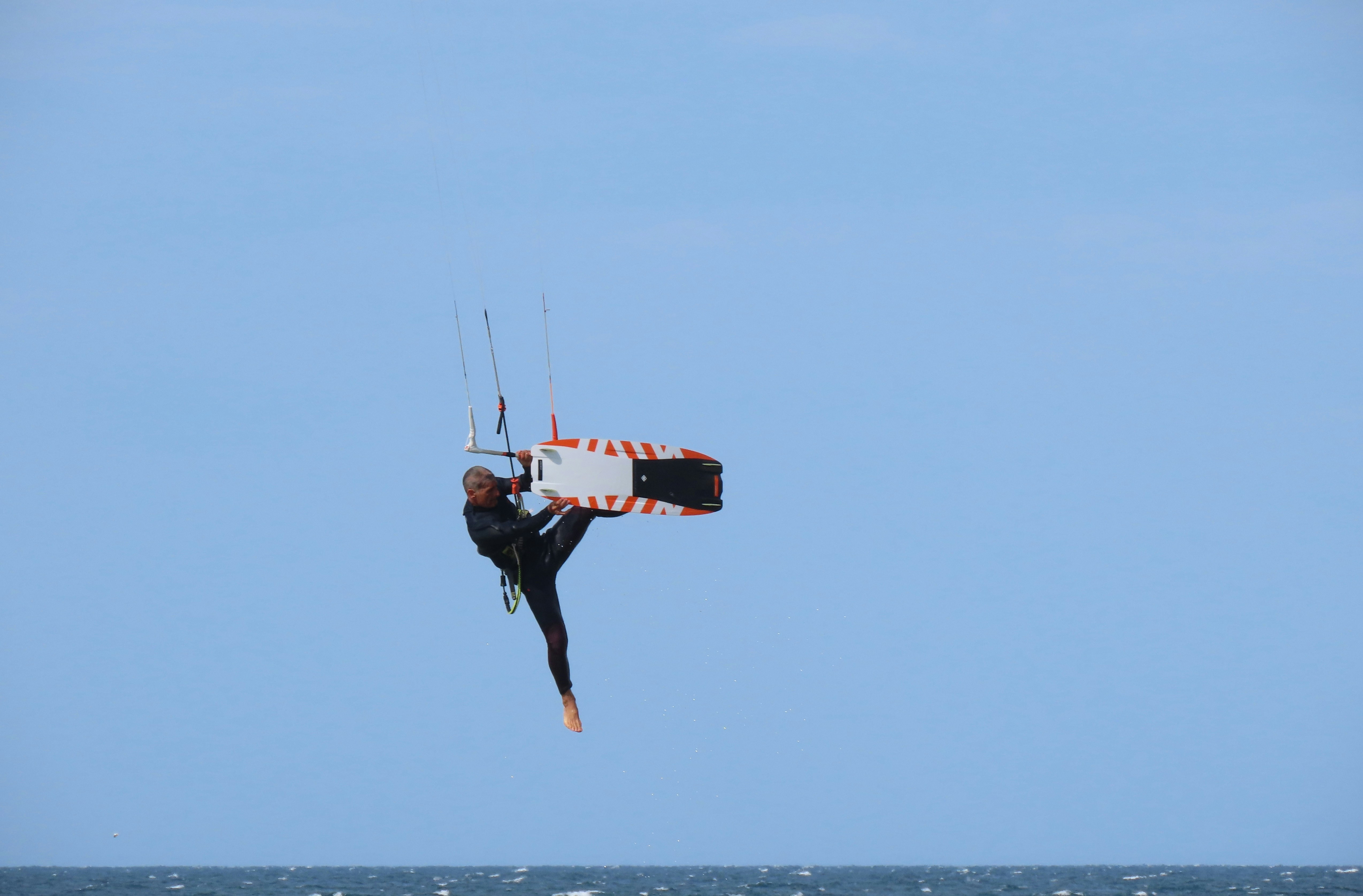 Midair Kitesurfer: Catching the Wind Above the Quiet Sea