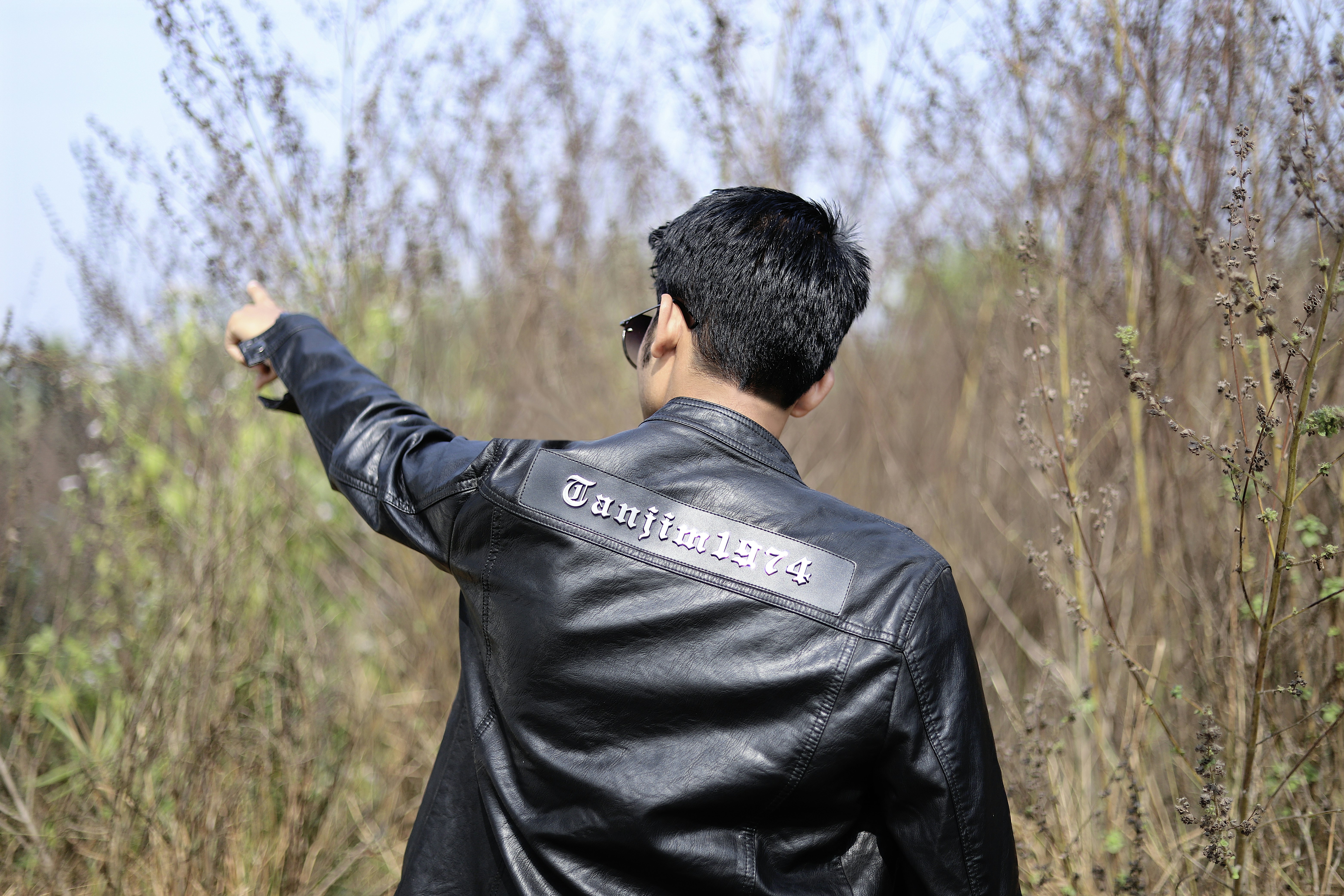 a man in a leather jacket pointing to something