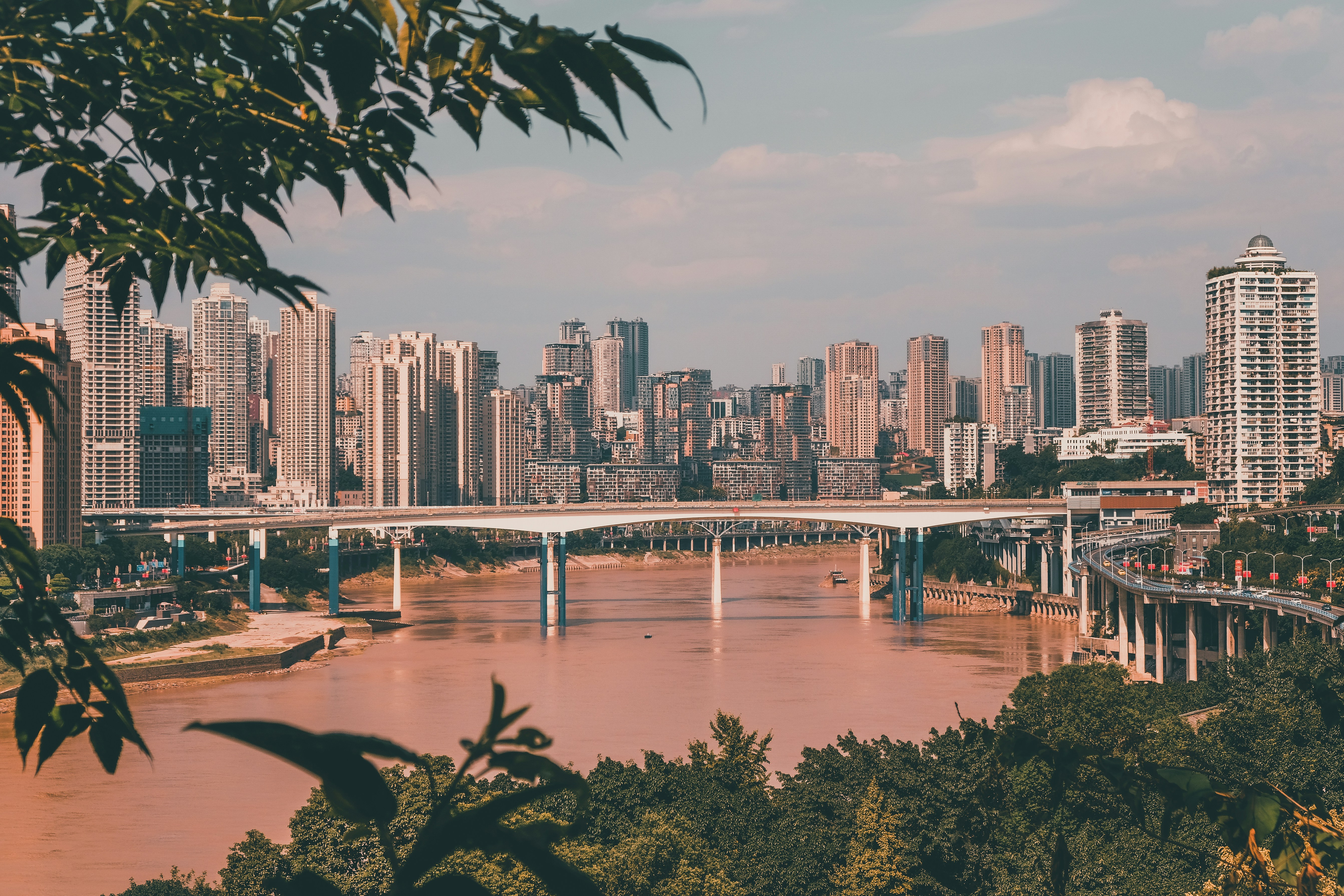 A bridge over a river with a city in the background photo – Free ...