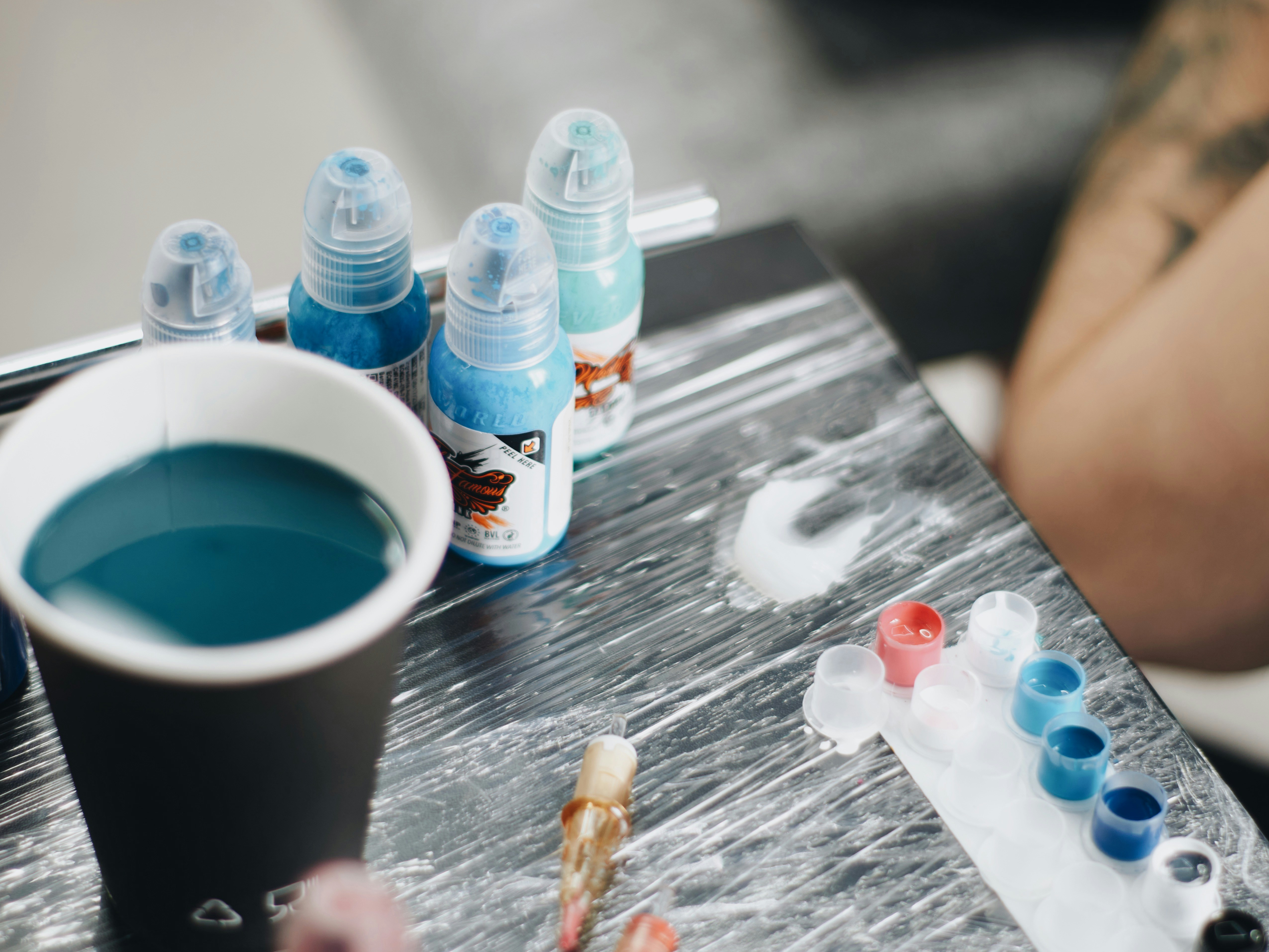 a table topped with lots of bottles of blue liquid