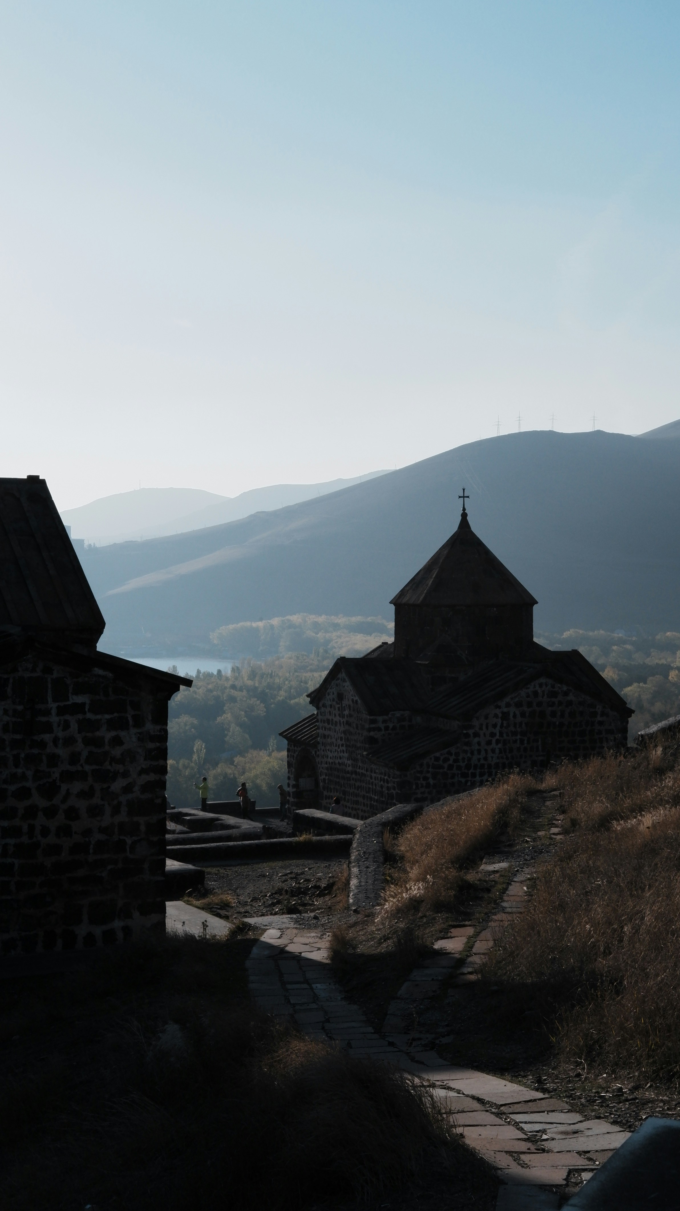 Hilltop Chapel Silhouette Against Layered Mountain Backdrop at Dusk