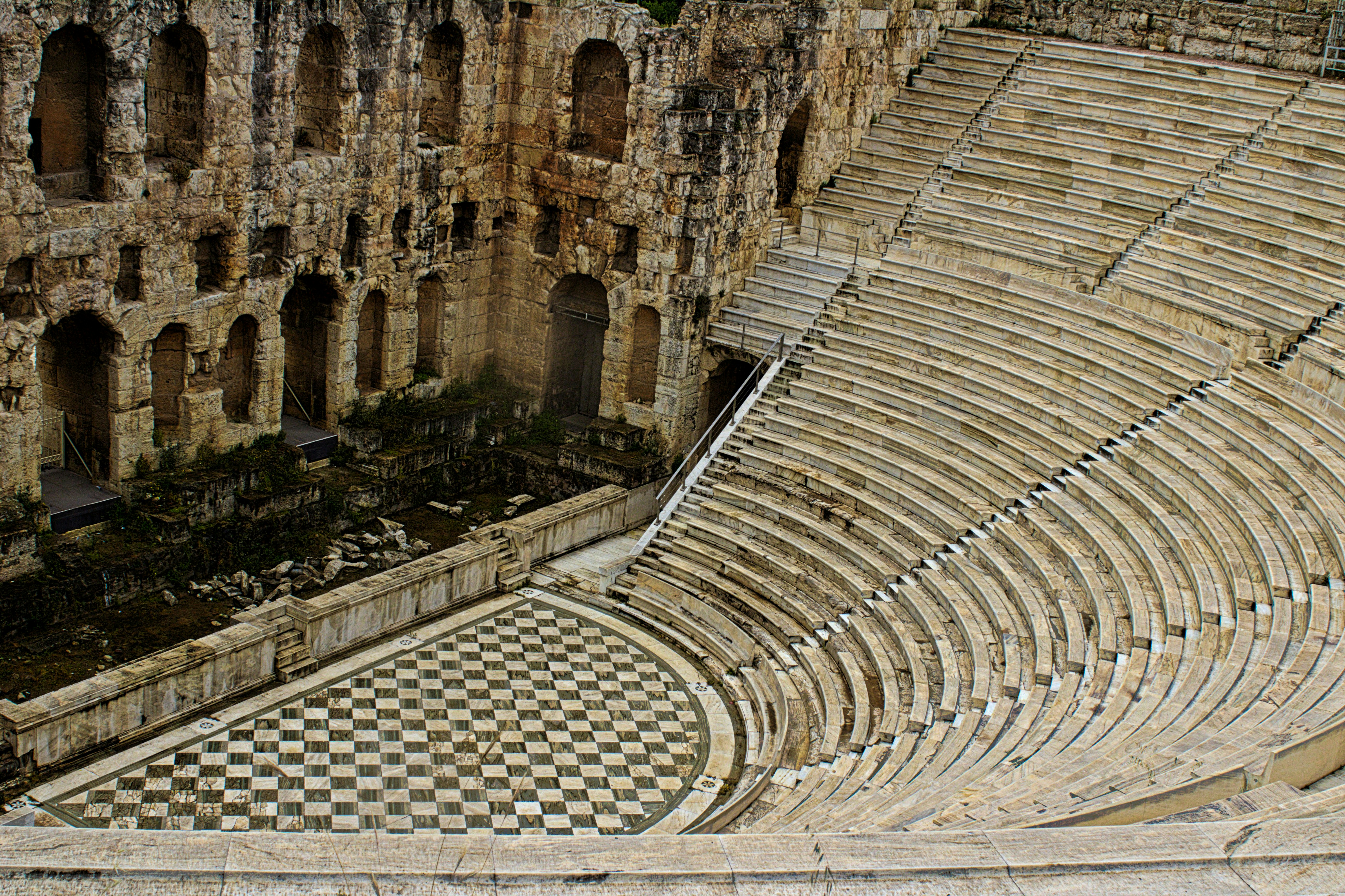 Historic amphitheater showcasing intricate stone architecture and a patterned floor, hinting at its former grandeur.