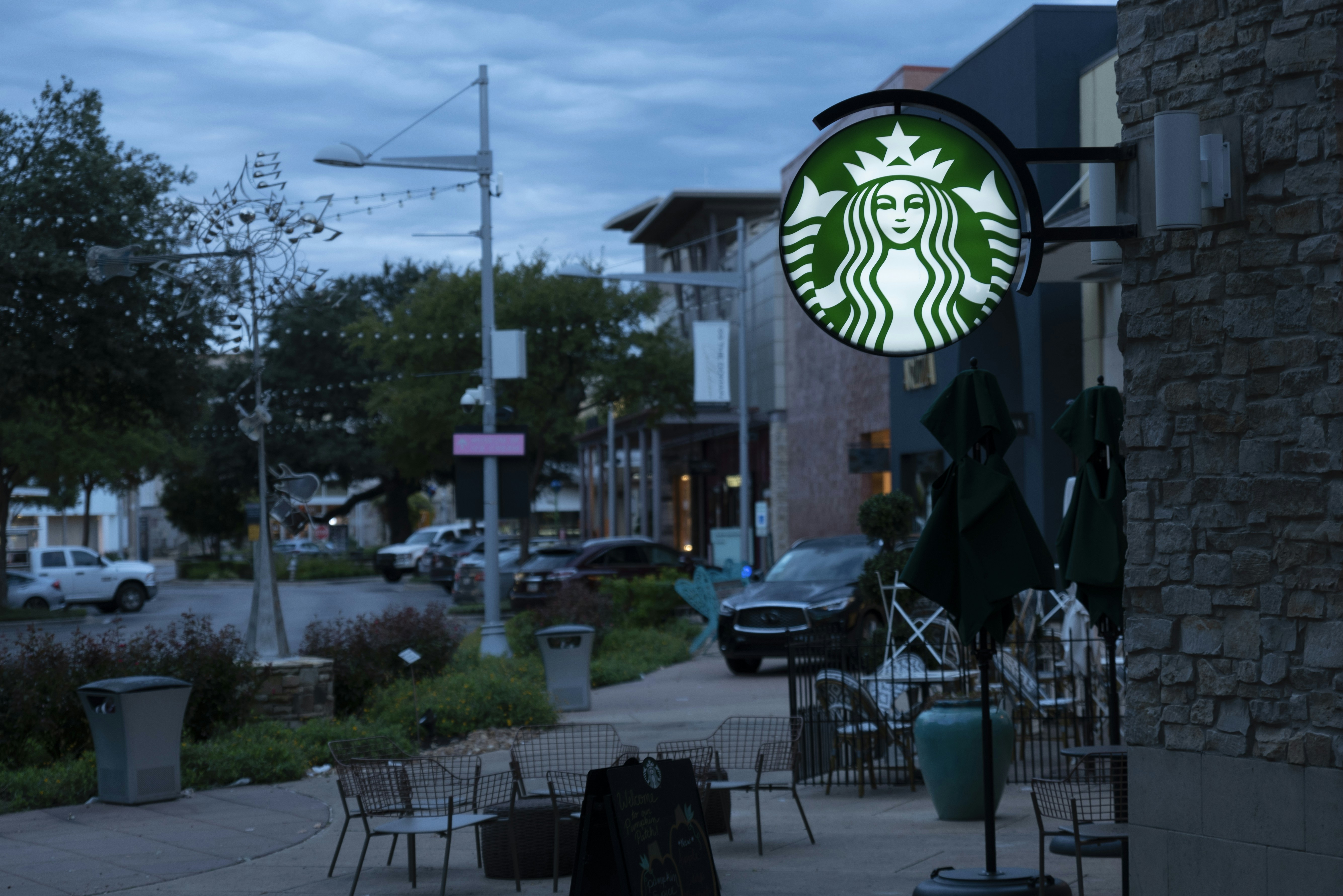 A starbucks sign hanging from the side of a building photo – Free ...