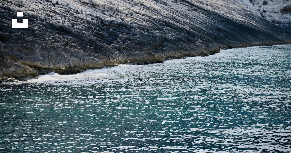 Un Cuerpo De Agua Cerca De Un Acantilado Rocoso Foto Imagen De Vis