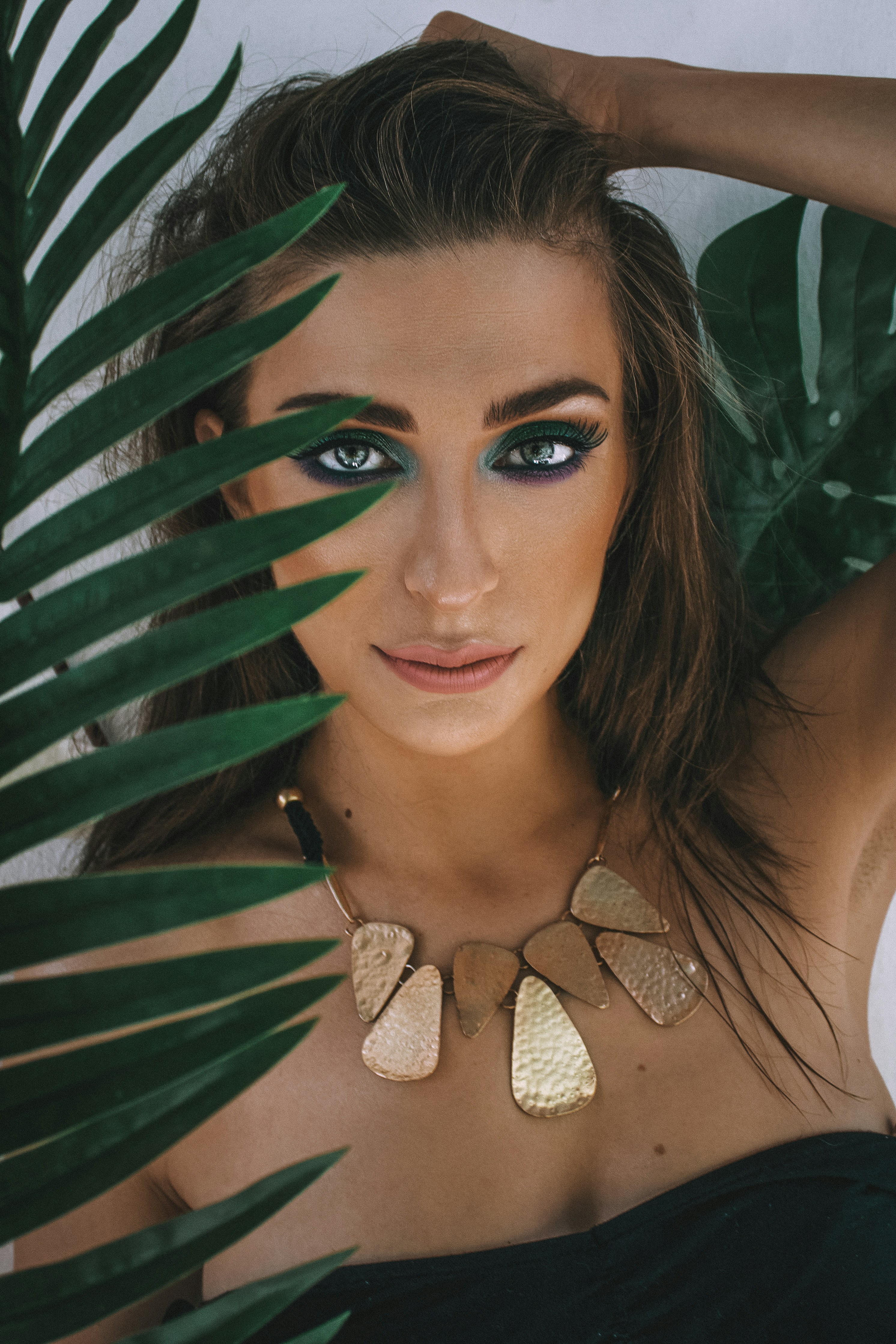 Emerald gaze through tropical leaves: a portrait of color and texture