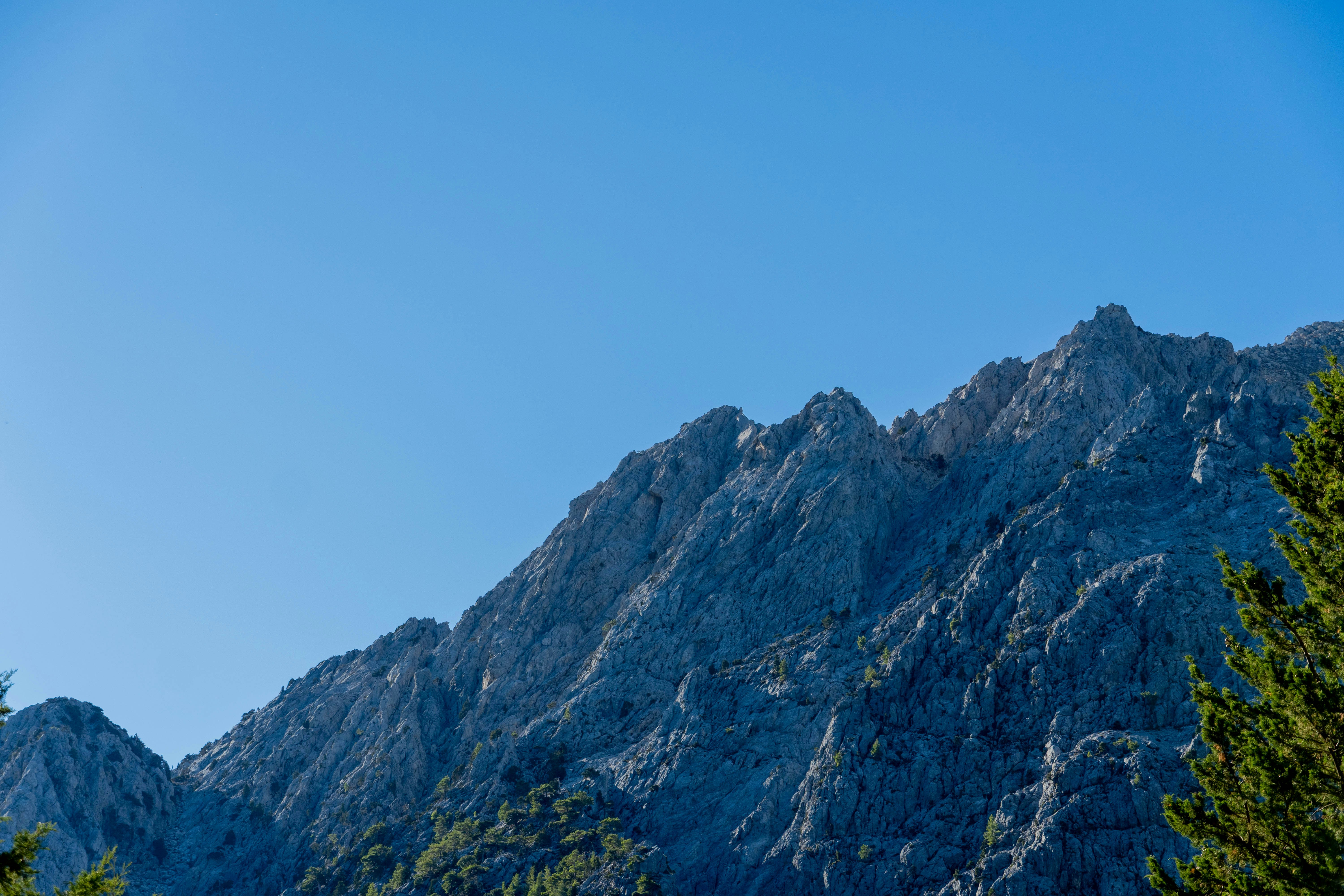A view of the top of a mountain from below photo – Free Grey Image on ...