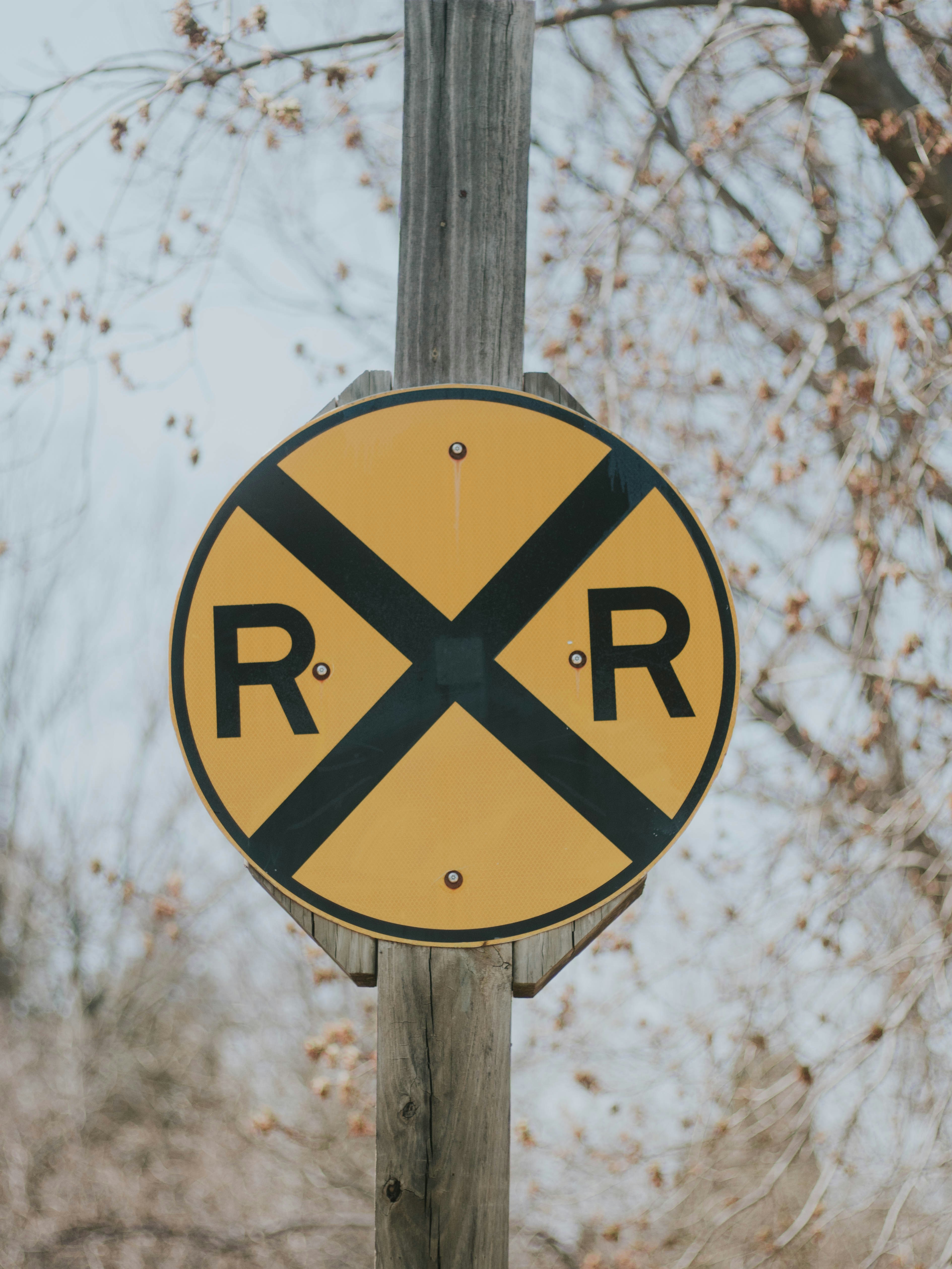 A railroad crossing sign on a wooden pole photo – Free Sign Image on ...