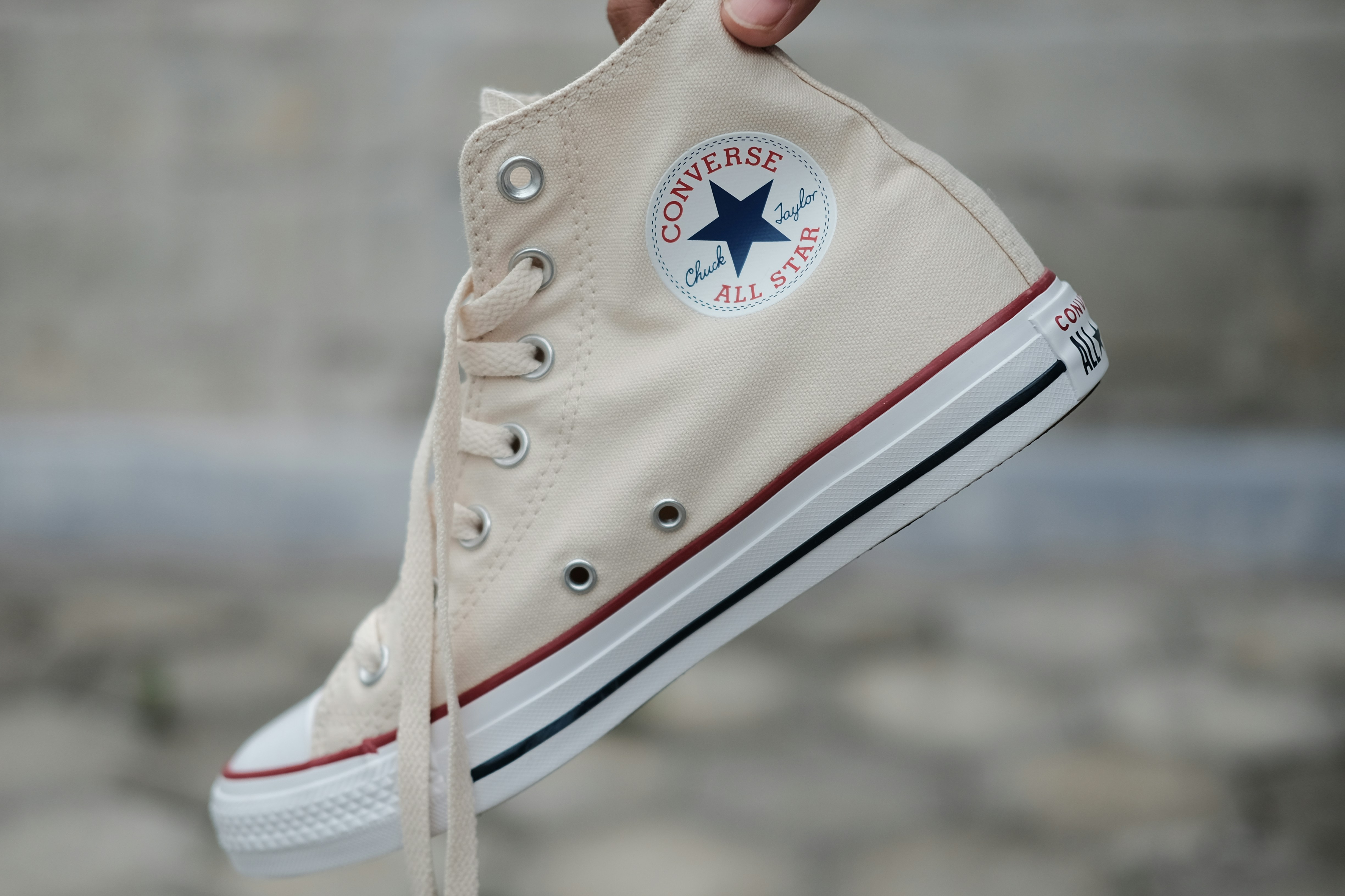 A person holding a pair of white converse shoes photo – Free Clothing ...