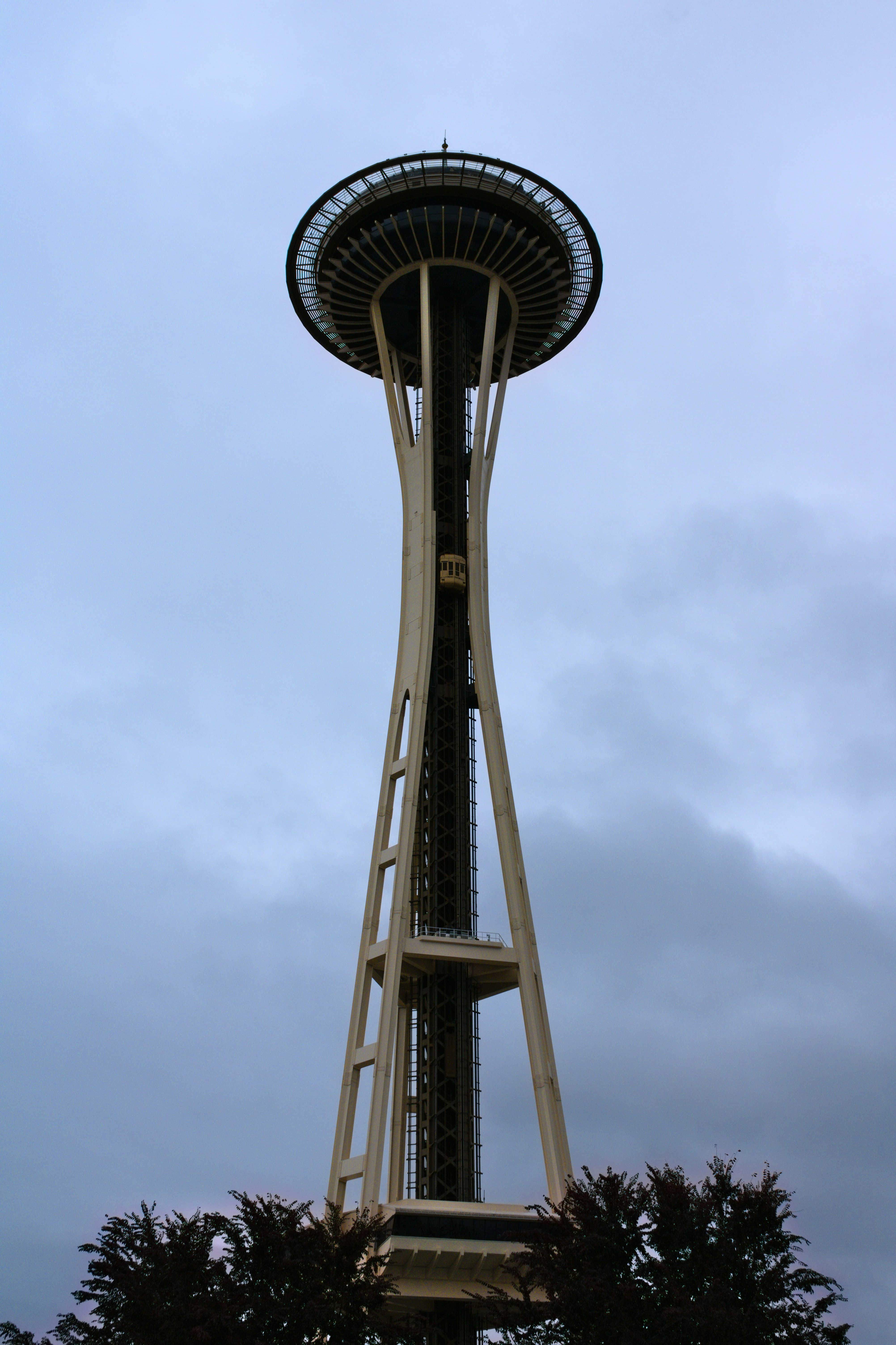 Space Needle in Seattle, Washington with elevator partway up on overcast day