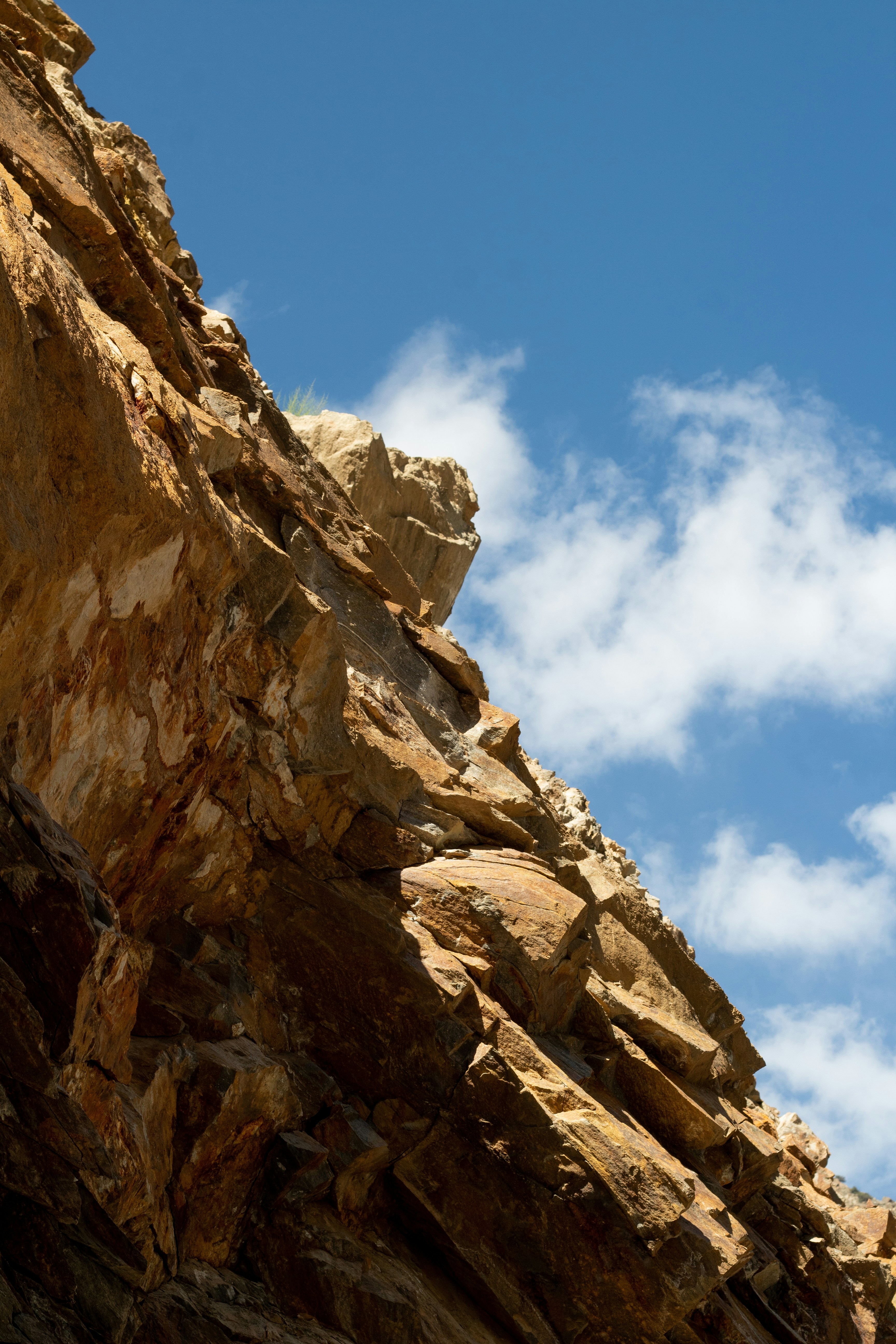 Jagged rock formations rise against a bright blue sky, showcasing the textures and layers of geological history.