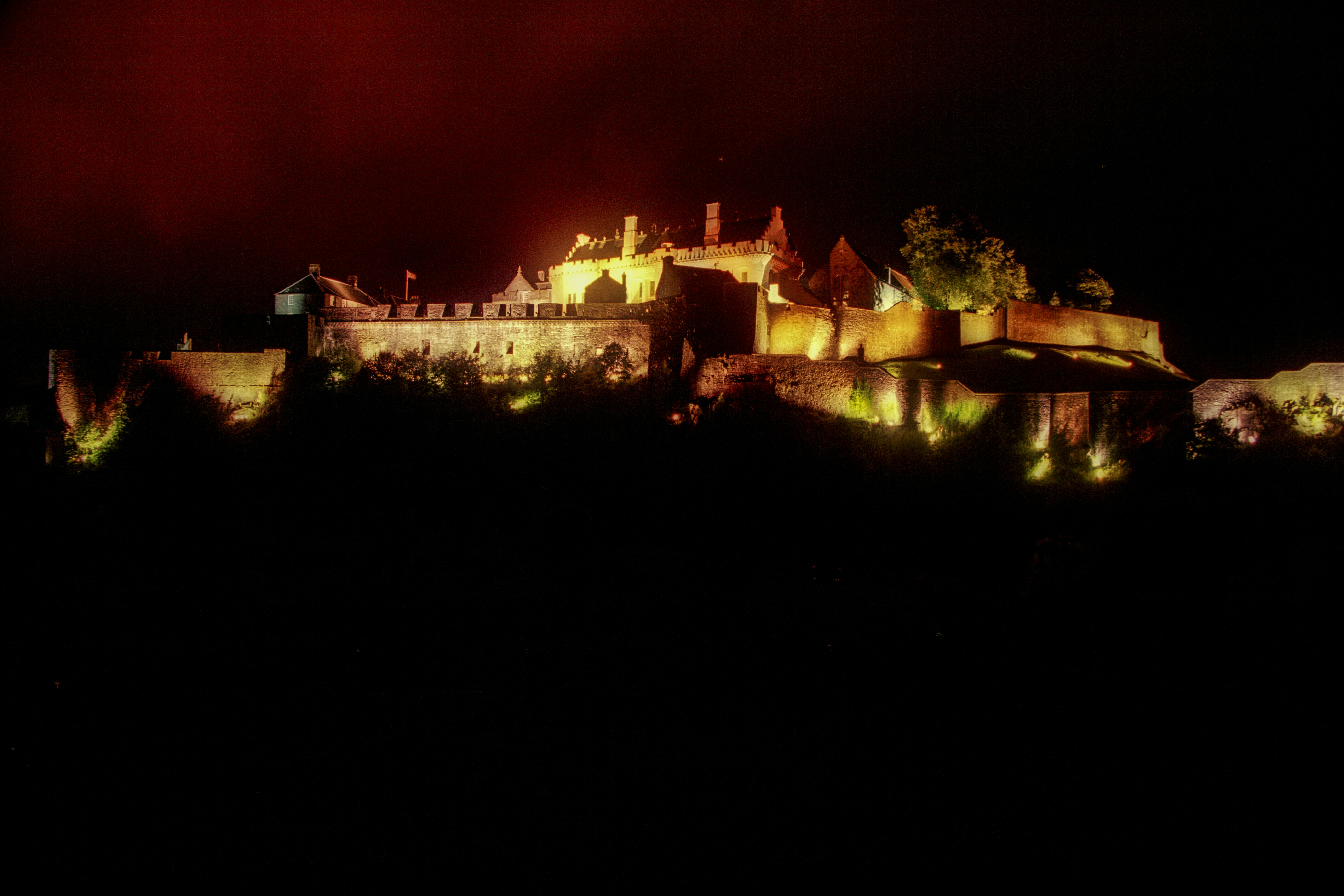 A castle lit up at night with a red sky photo – Free Castle hill Image ...