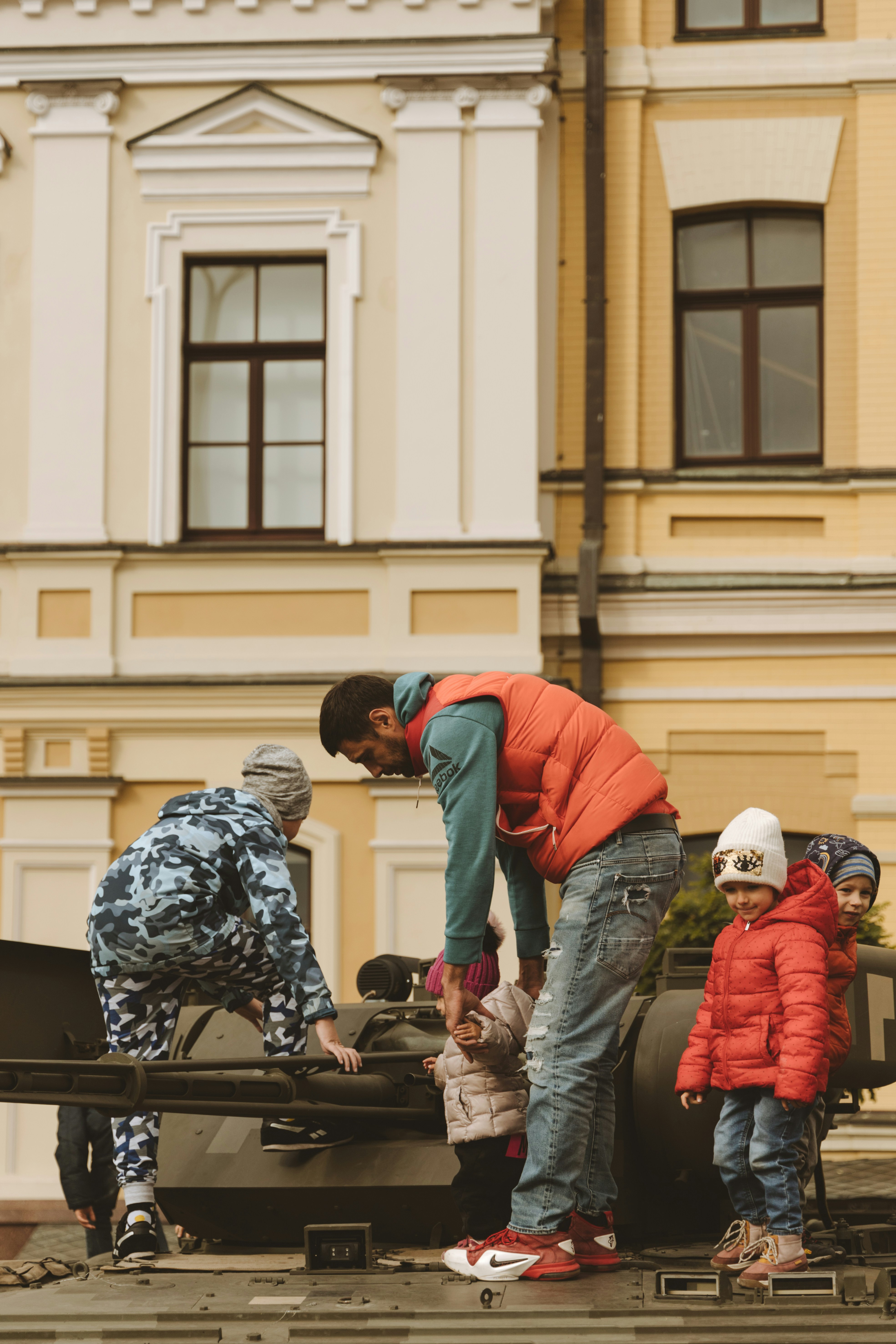 Helping Hands by the Tank in a Sunlit City Square