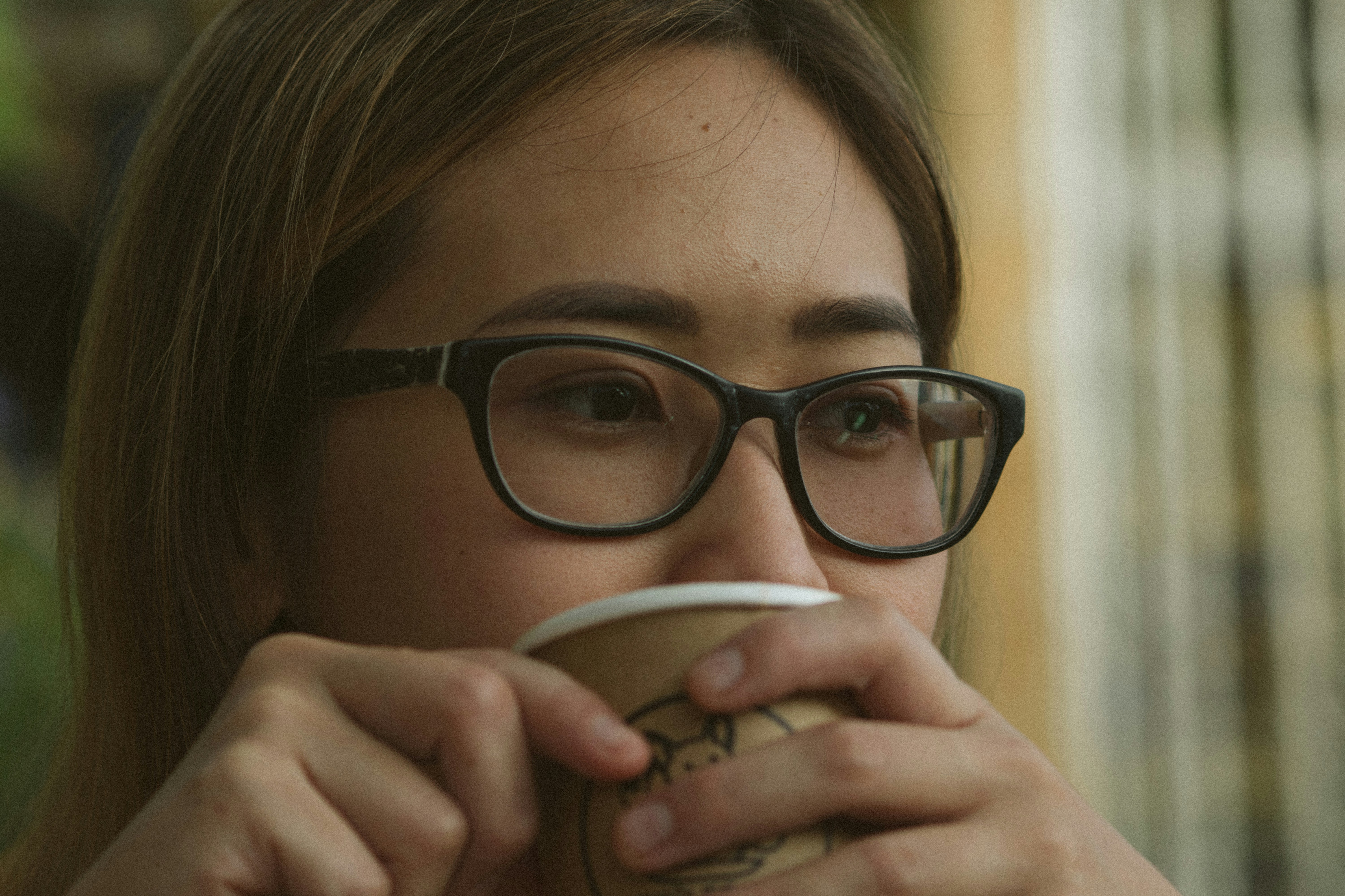 A woman wearing glasses drinking from a coffee cup photo – Free Human Image on Unsplash