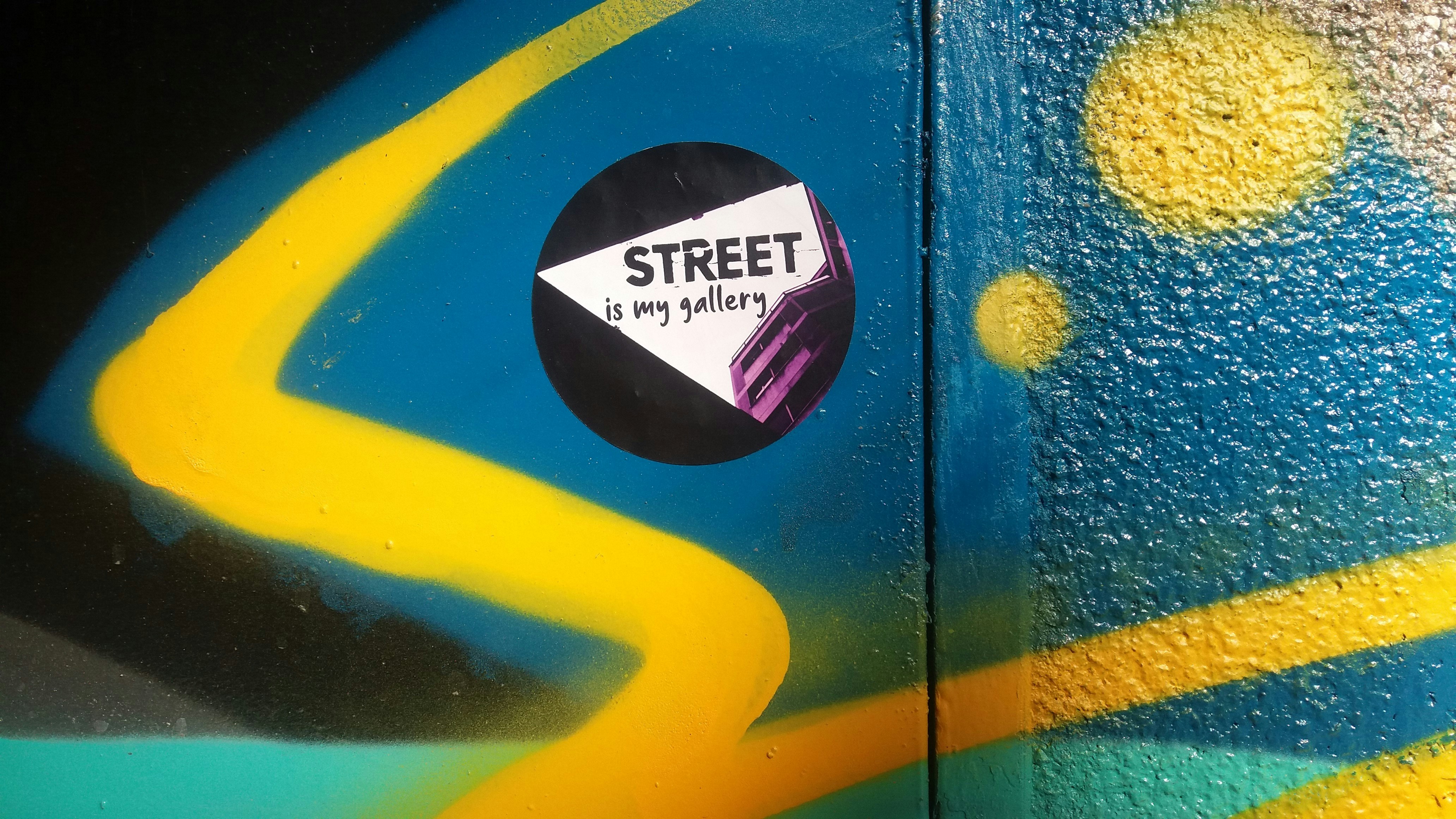 Sticker on graffiti finds its glow amid blue-yellow swirl
