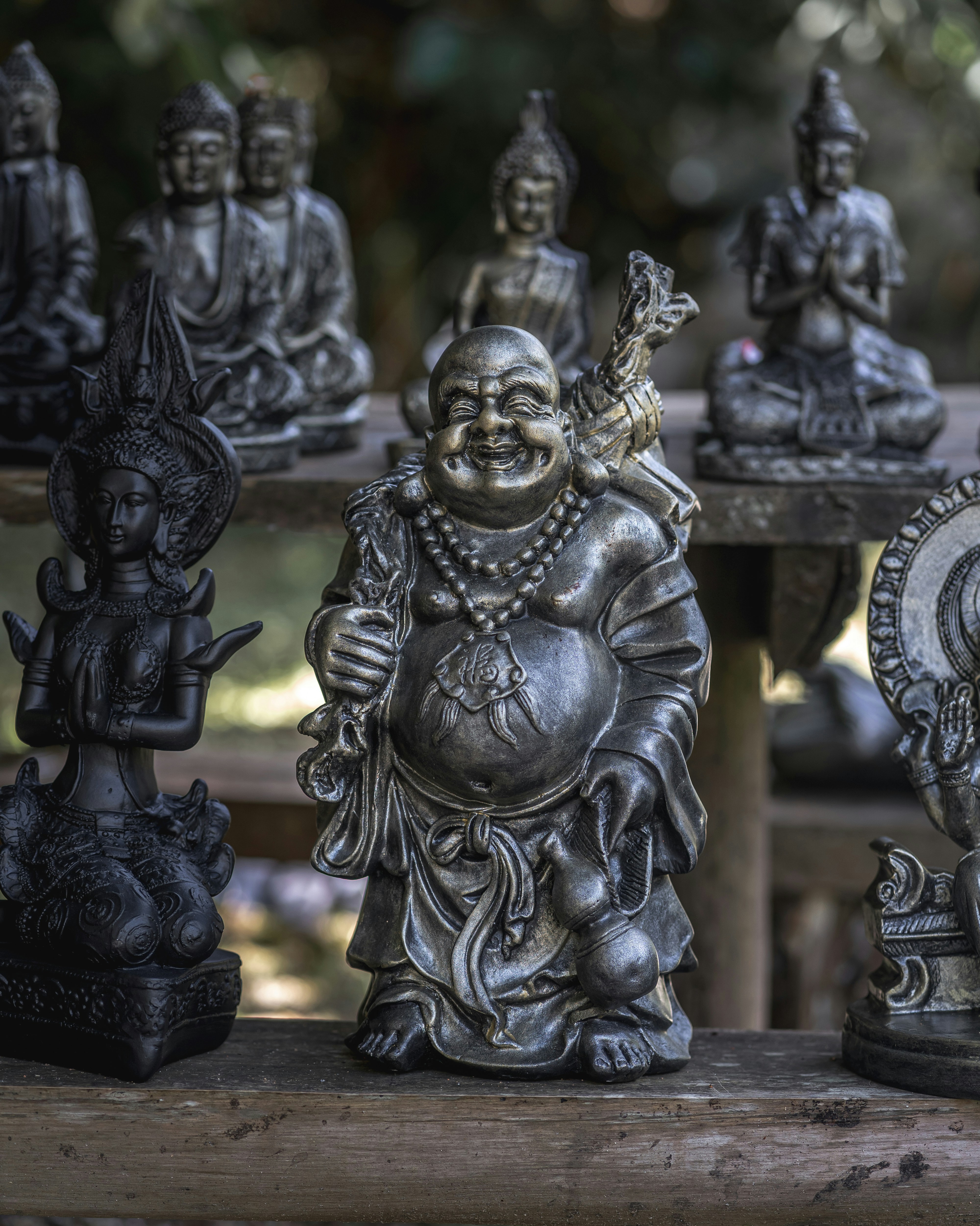 Laughing Buddha Centerstage Amid a Row of Shadowed Stone Statues