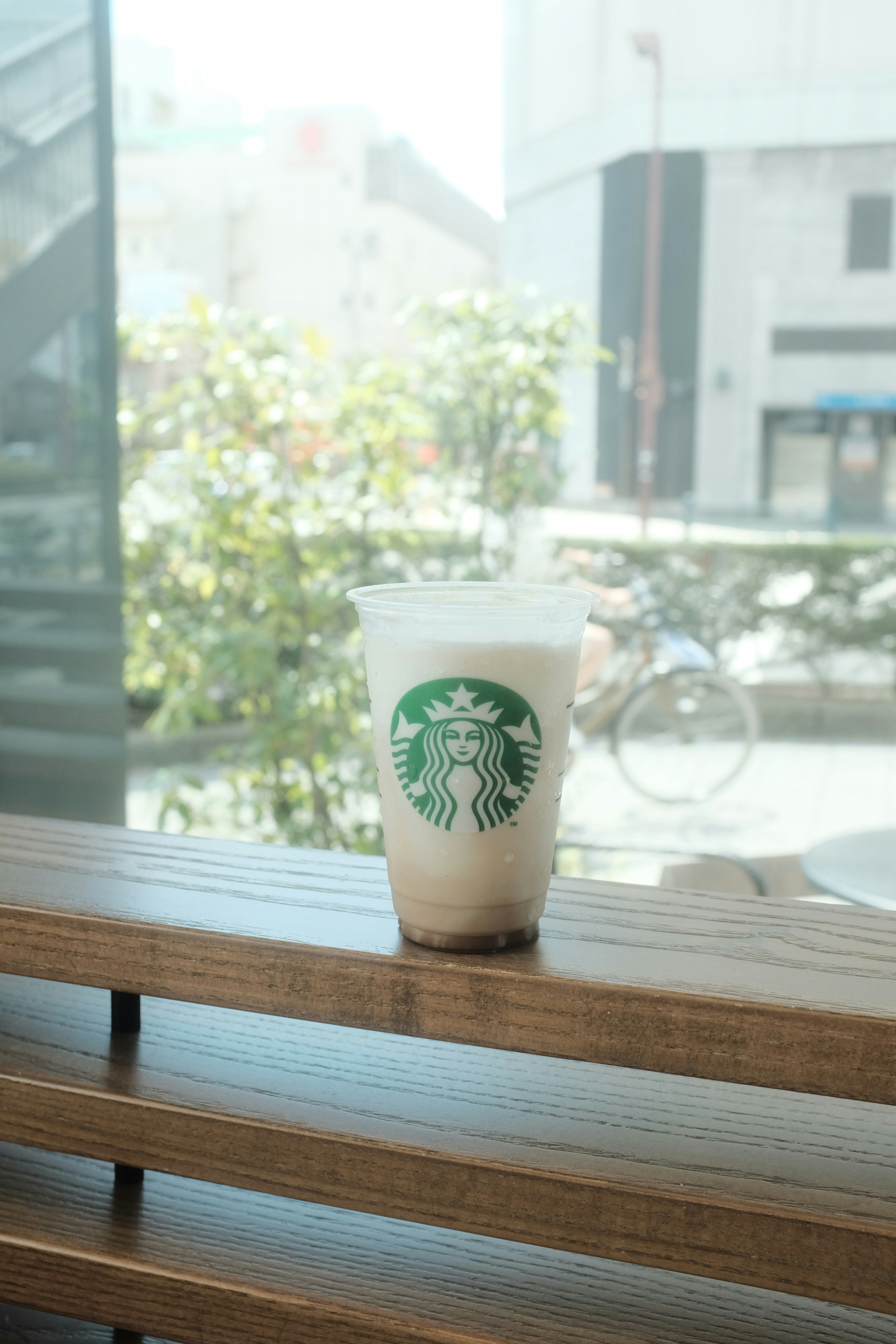 A starbucks cup sitting on a wooden bench photo – Free Restaurant Image ...