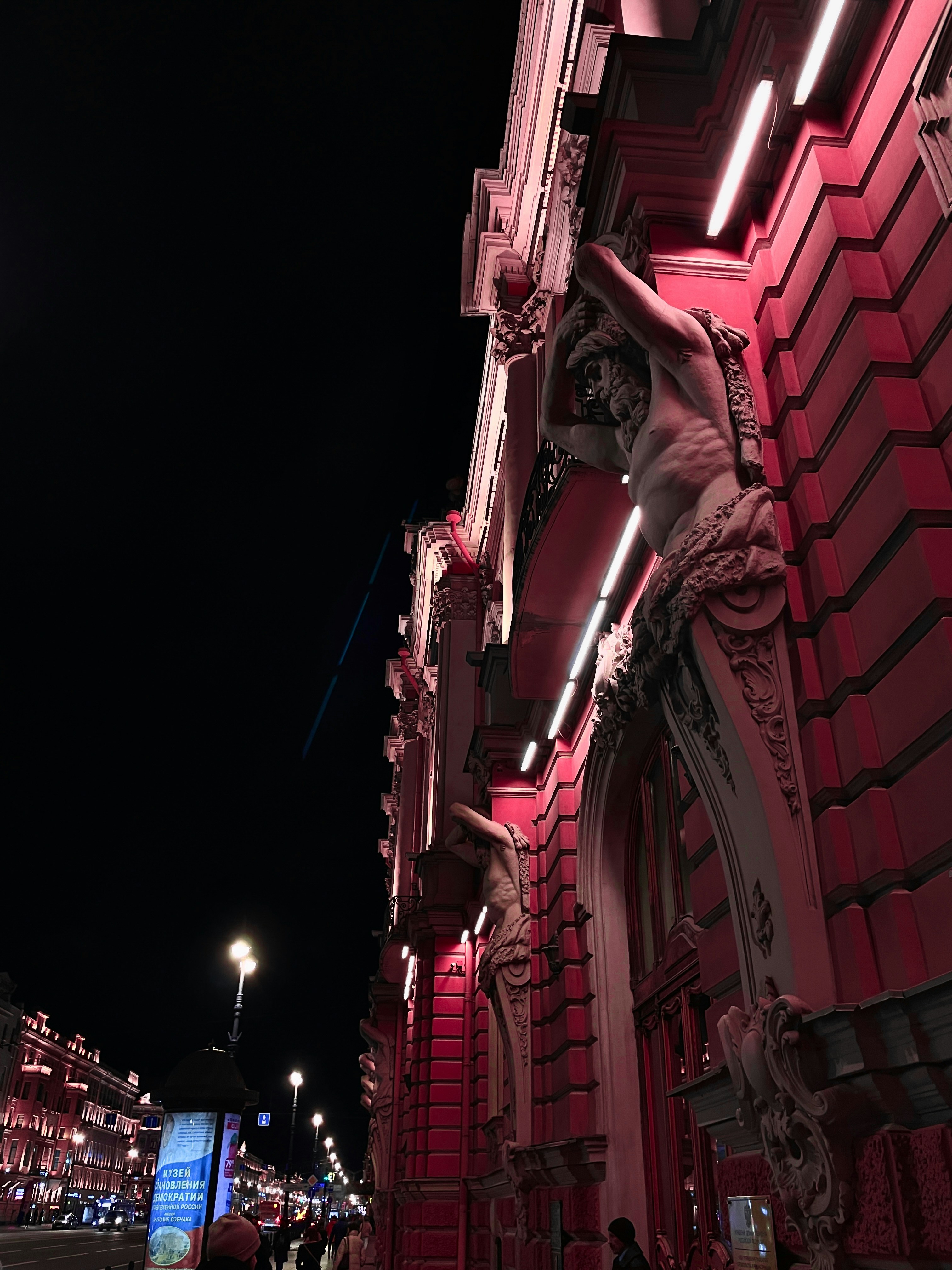 Neon Facade at Night: A Red-lit Triumph Over Stone