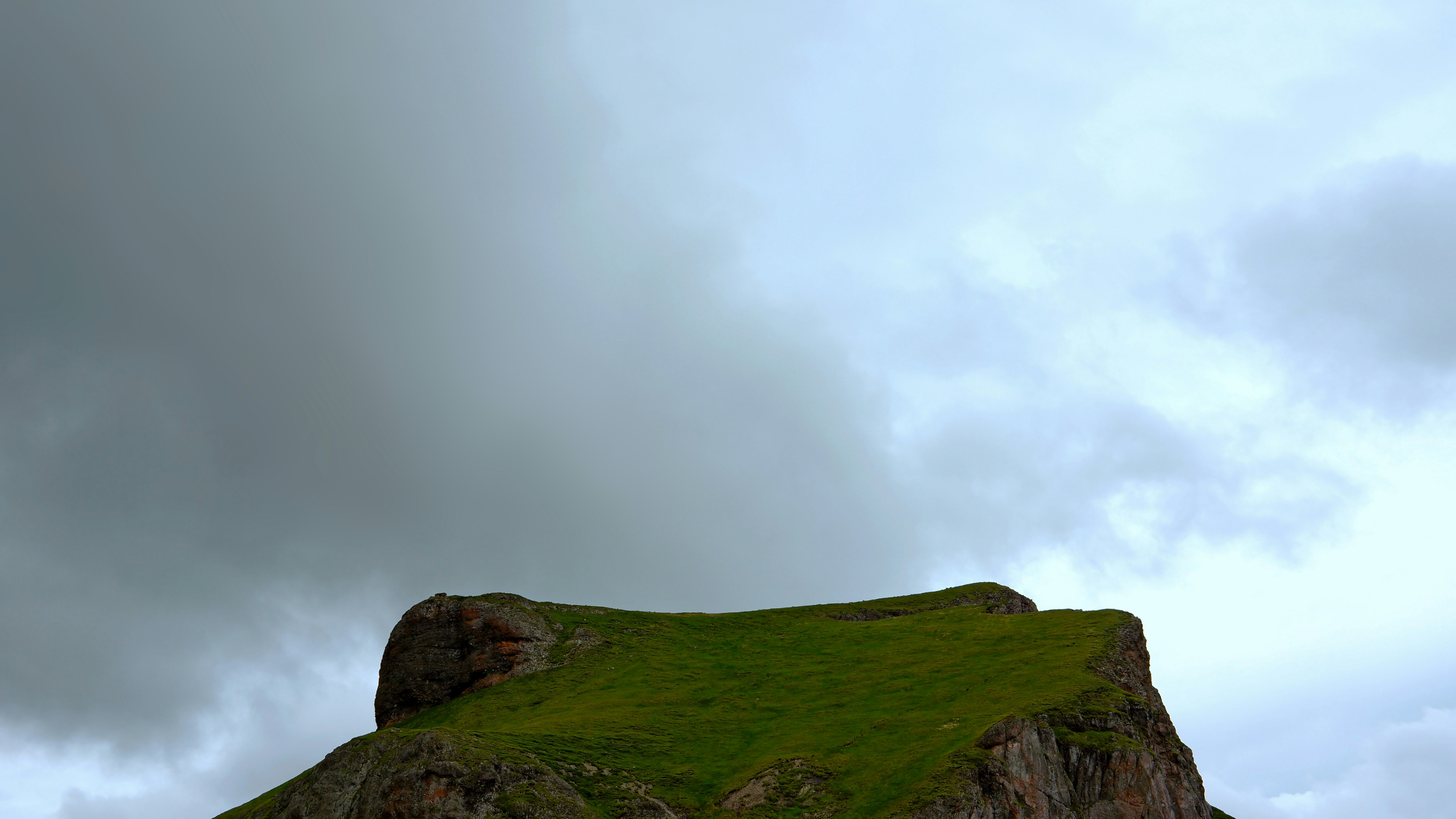 Foto zum Thema Ein großer Felsen mit einer Rasenfläche darauf ...