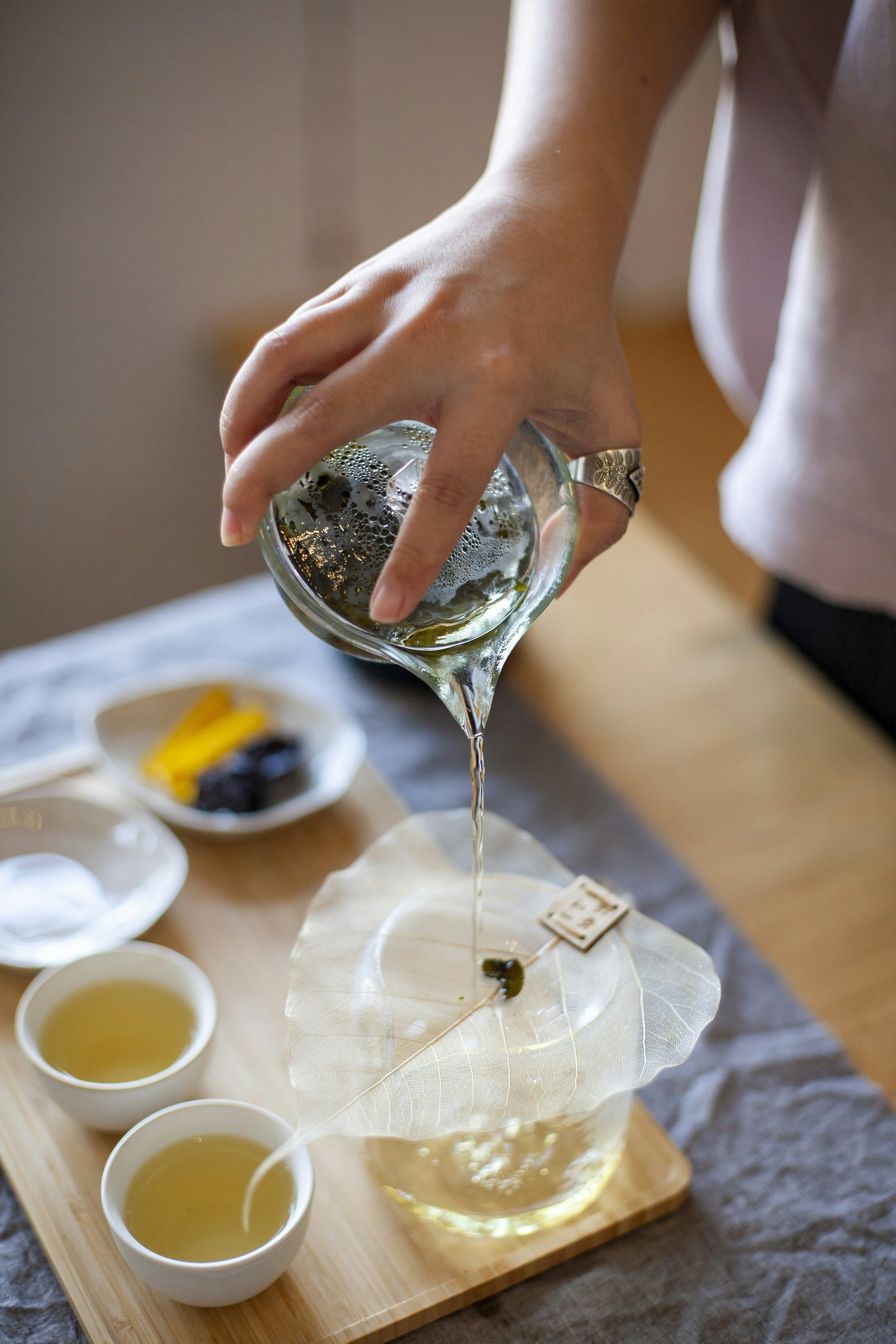 A person pouring tea into a cup on a tray photo – Free Human Image on ...