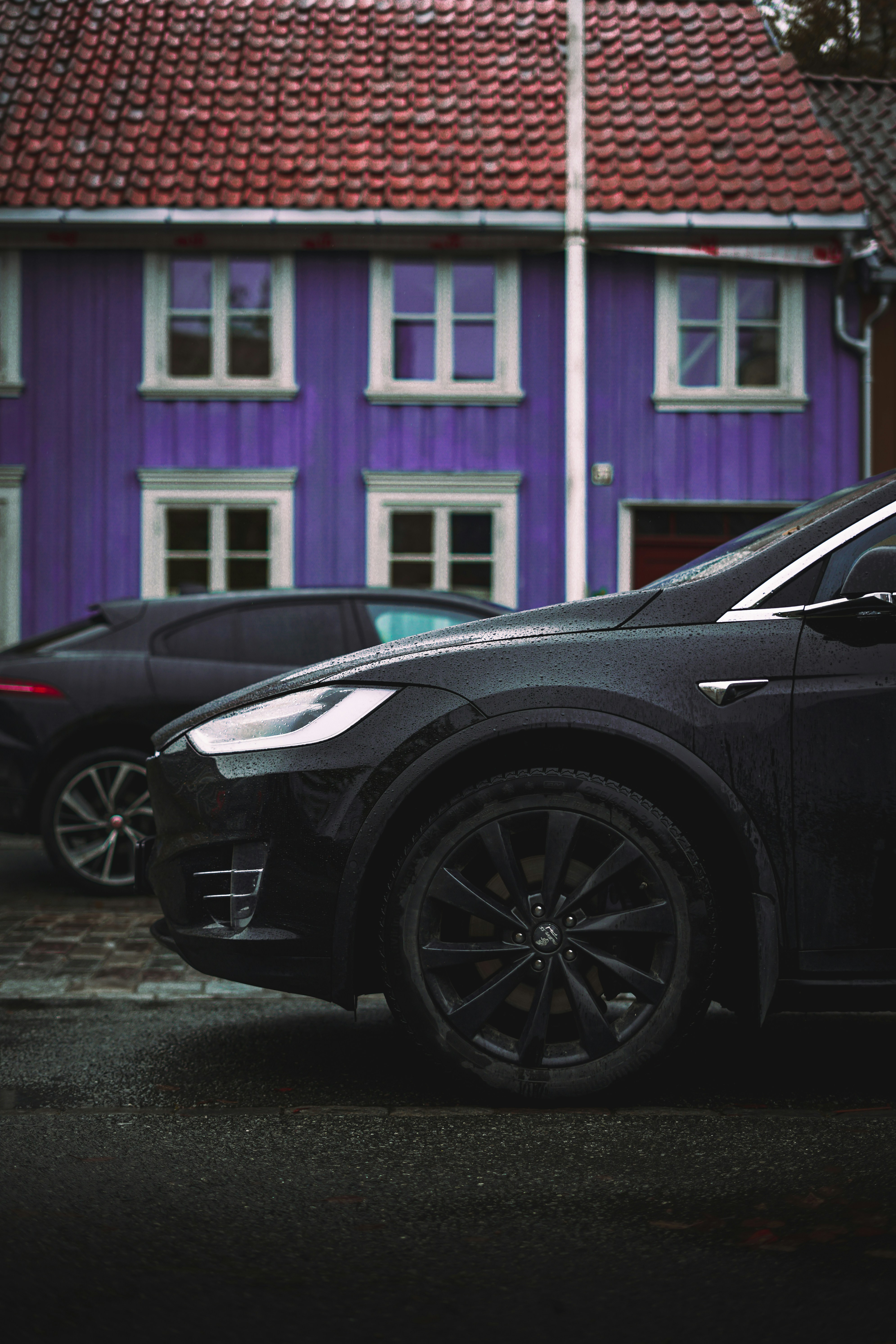 a black car parked in front of a purple house