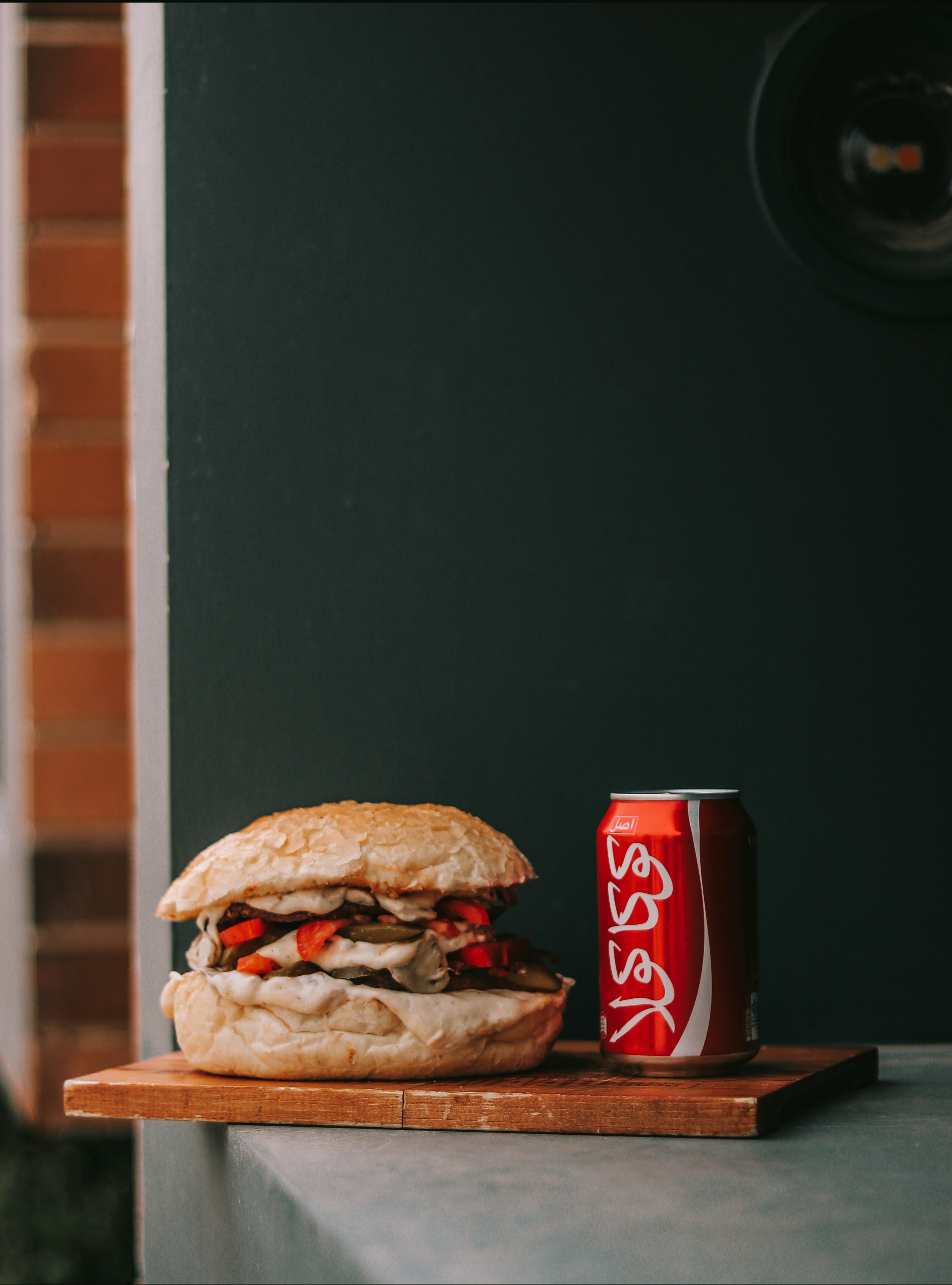 Burger on a Wooden Tray with a Soda Can in a Minimalist Kitchen