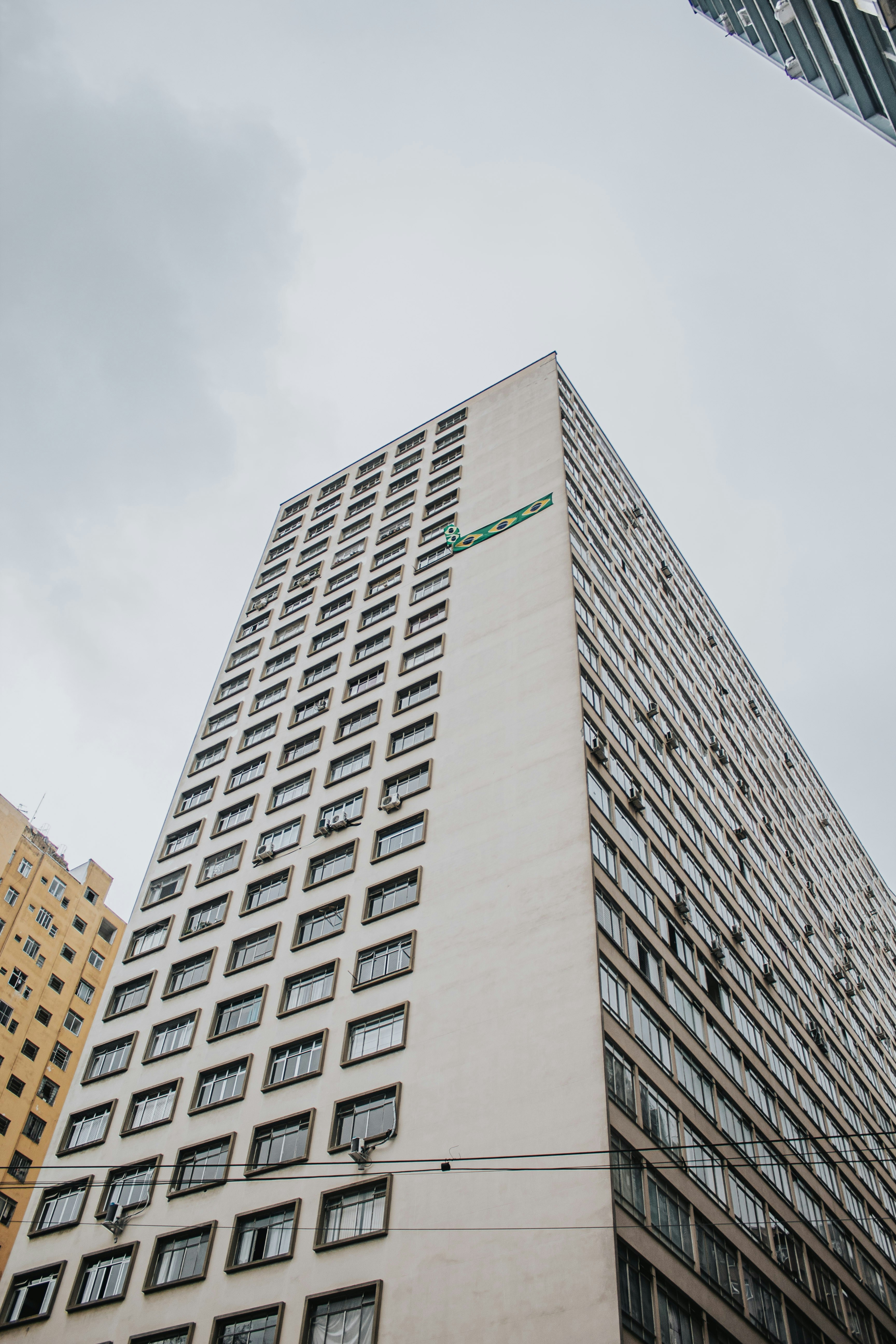 A tall white building with windows and a sky background photo – Free ...
