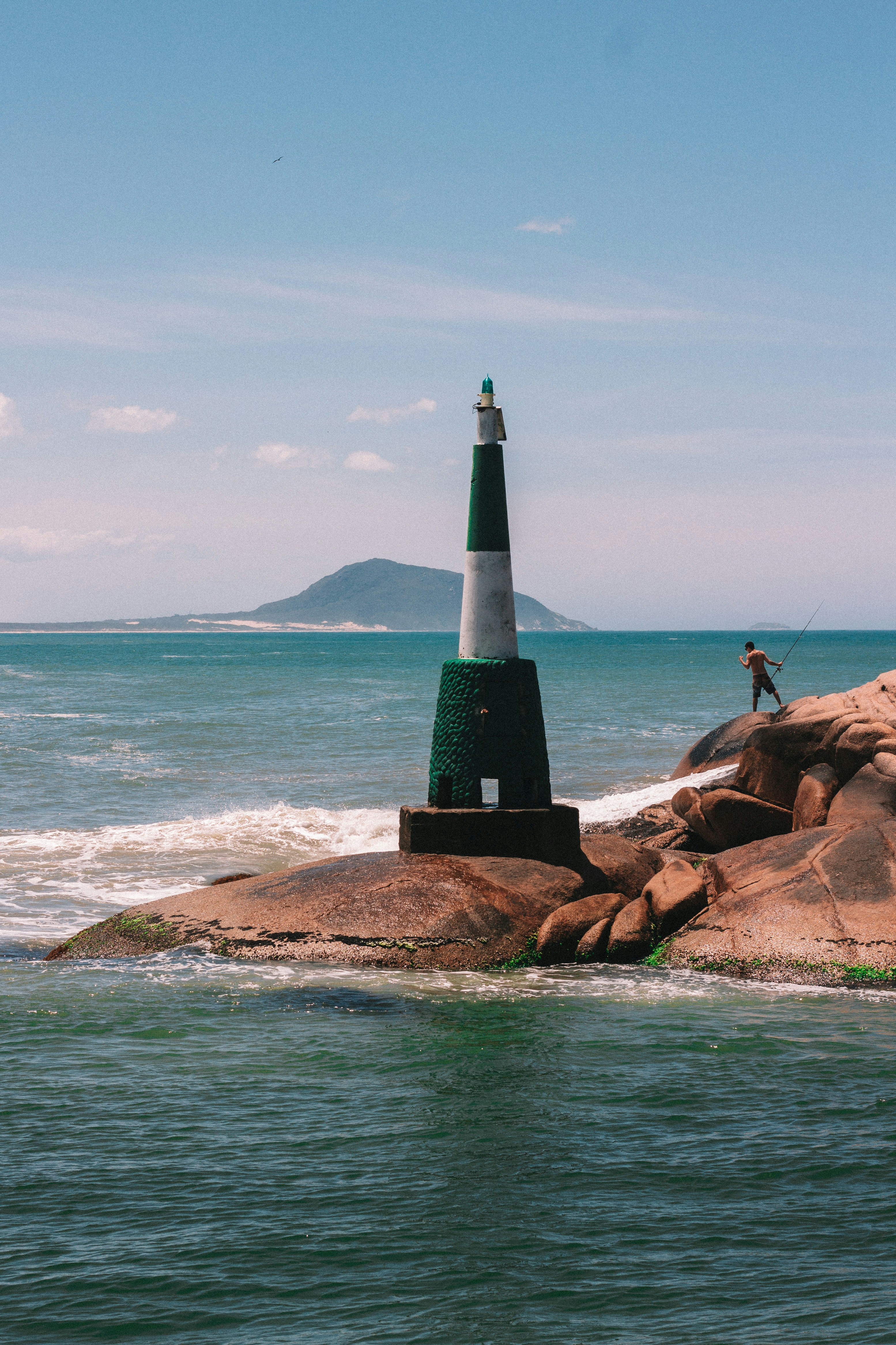 Beacon at the Breakers: A Quiet Seascape with a Fisher on the Rocks
