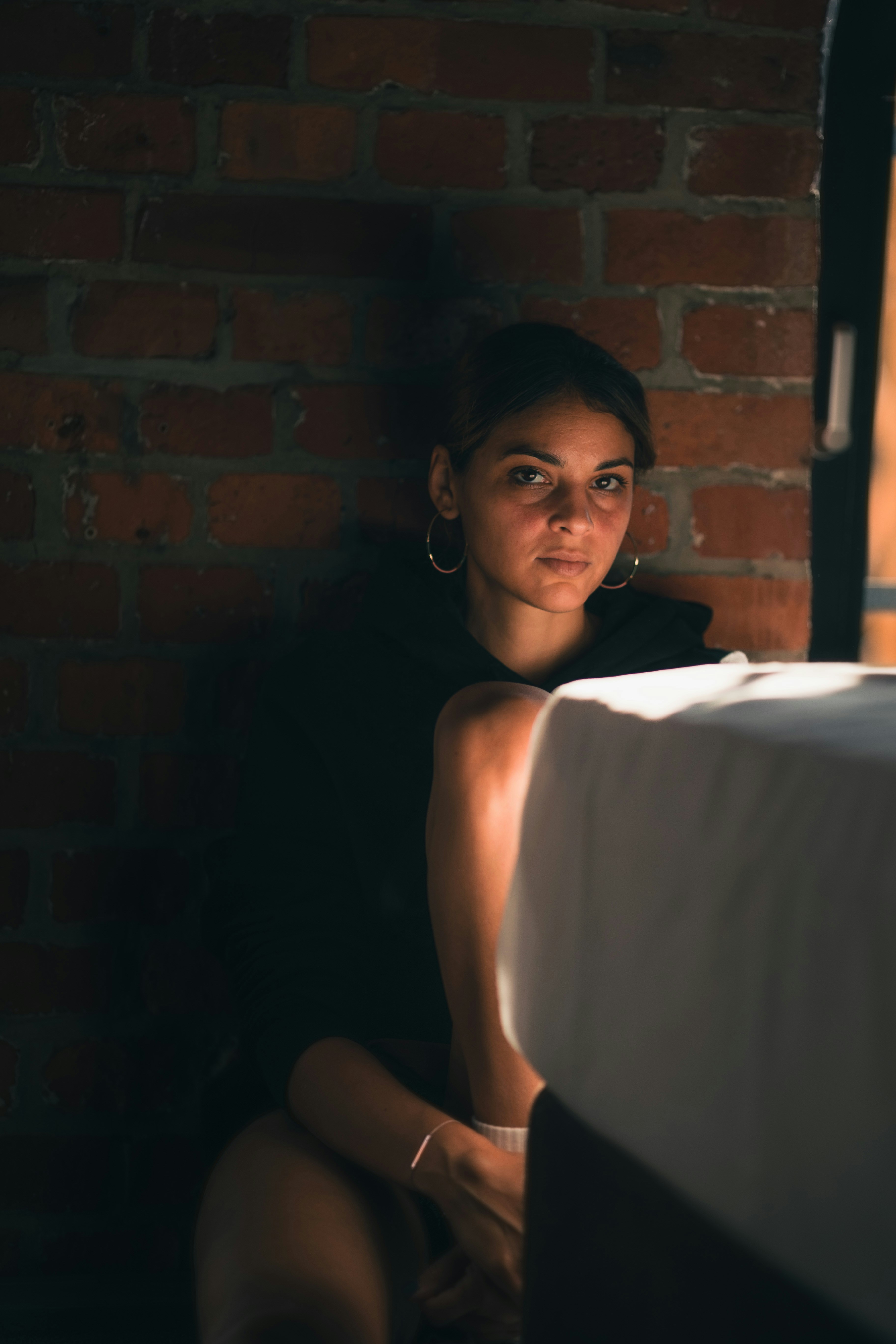 Shadowed Intimacy: A Quiet Moment in a Brick Chamber