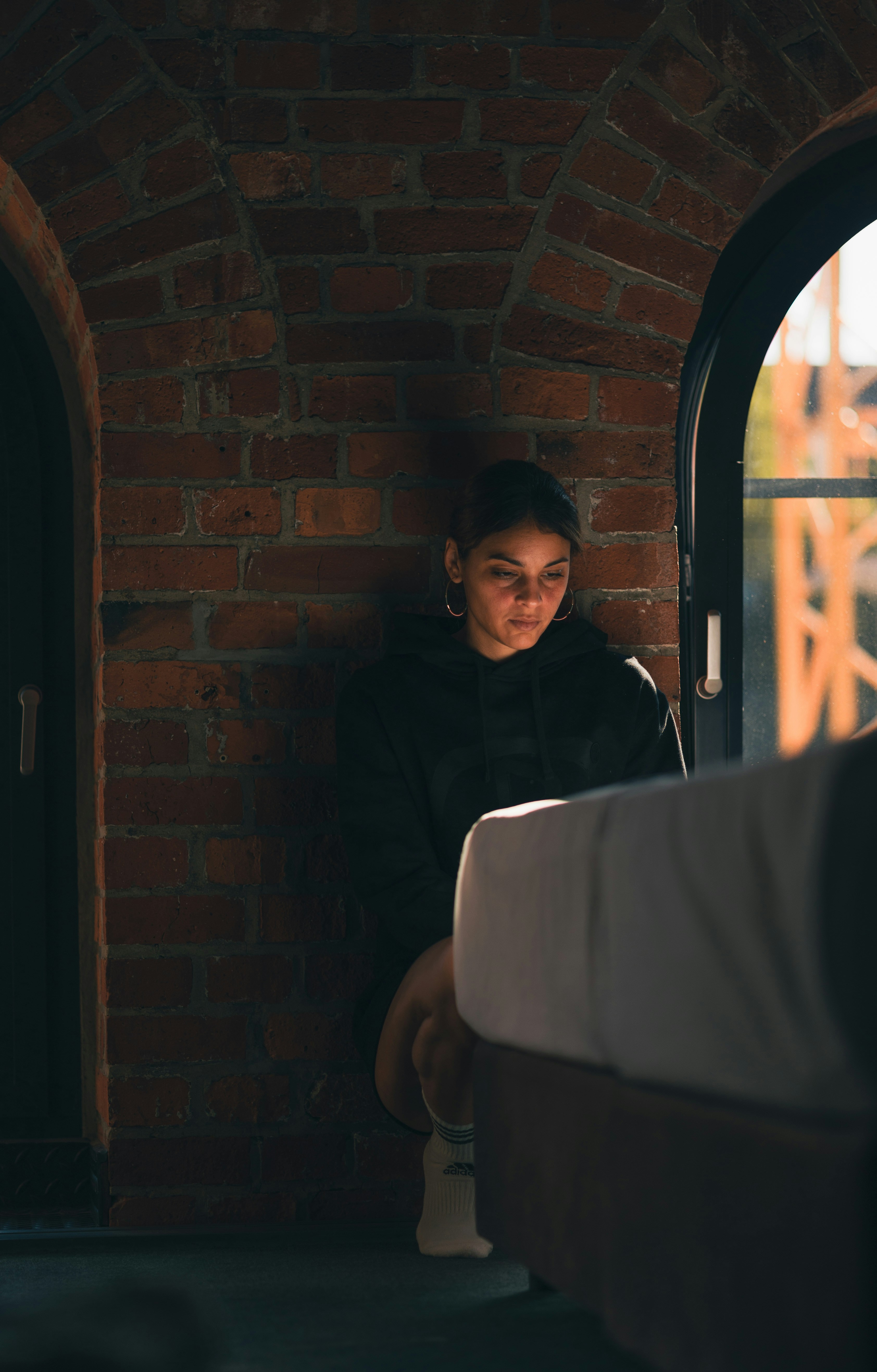Brick Arch Solitude: A Quiet Moment by Window Light
