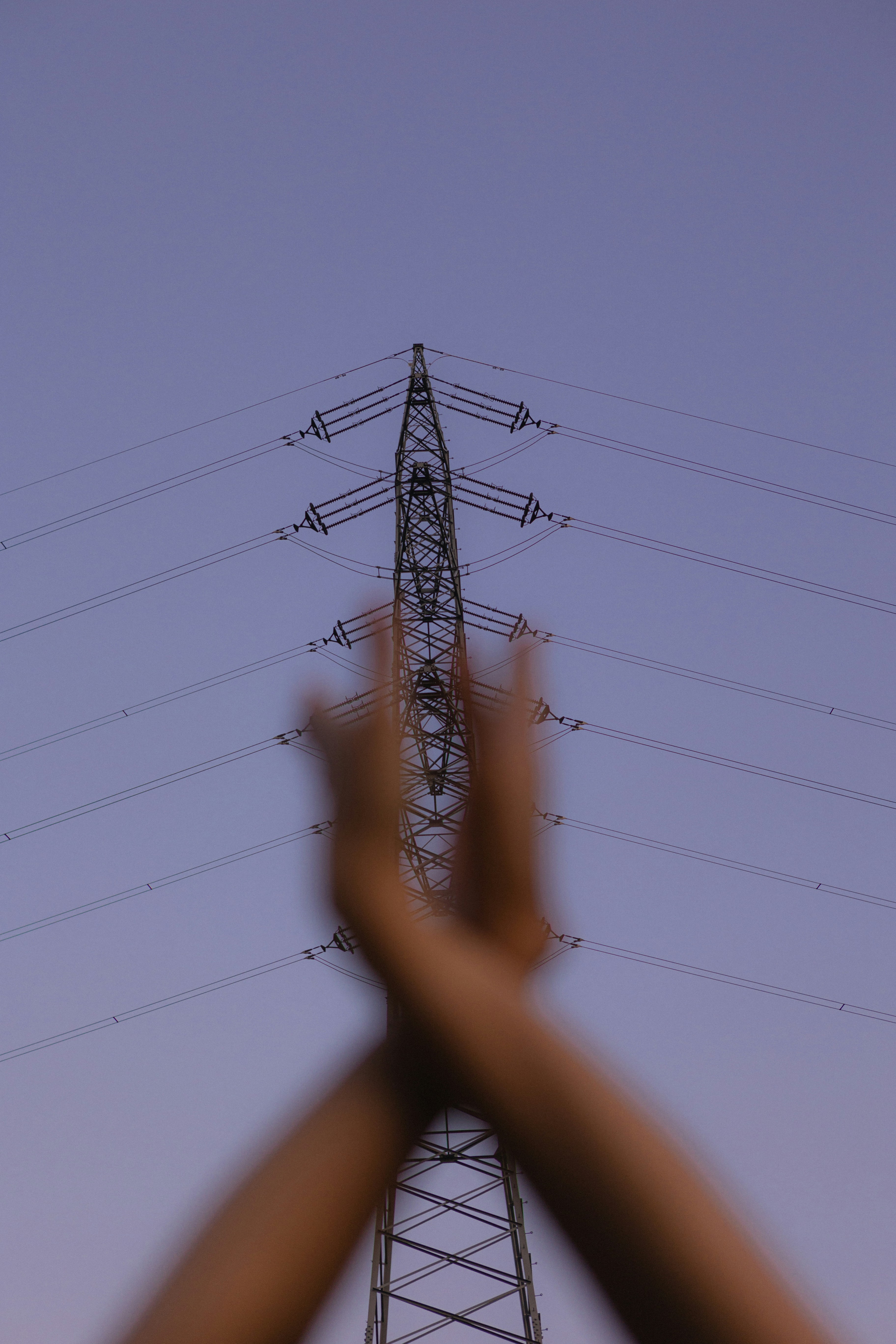 Crossed Hands Framing a Lattice Giant Under a Purple Sky