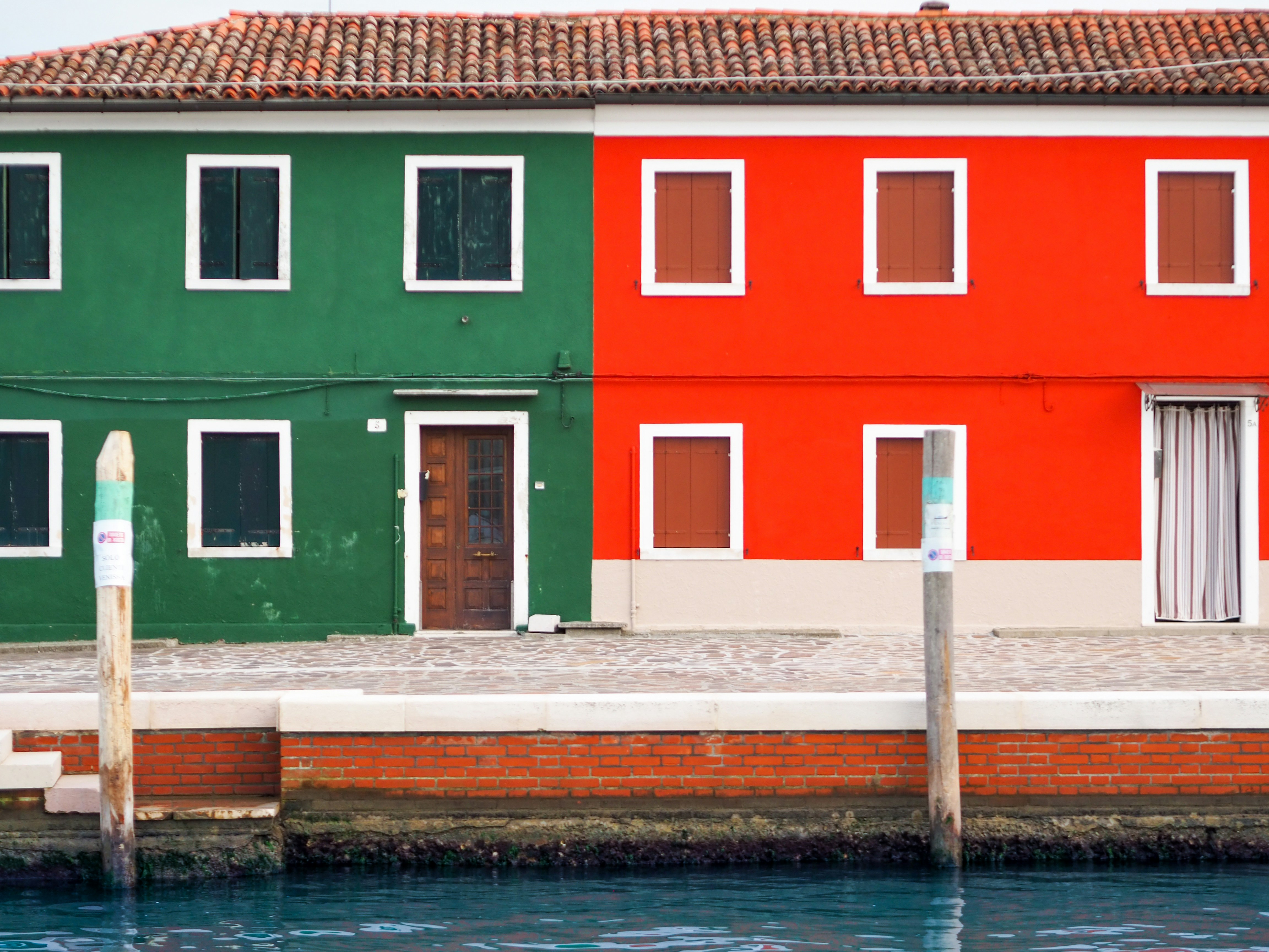 Verdant and Vermilion Facades Along a Quiet Canal