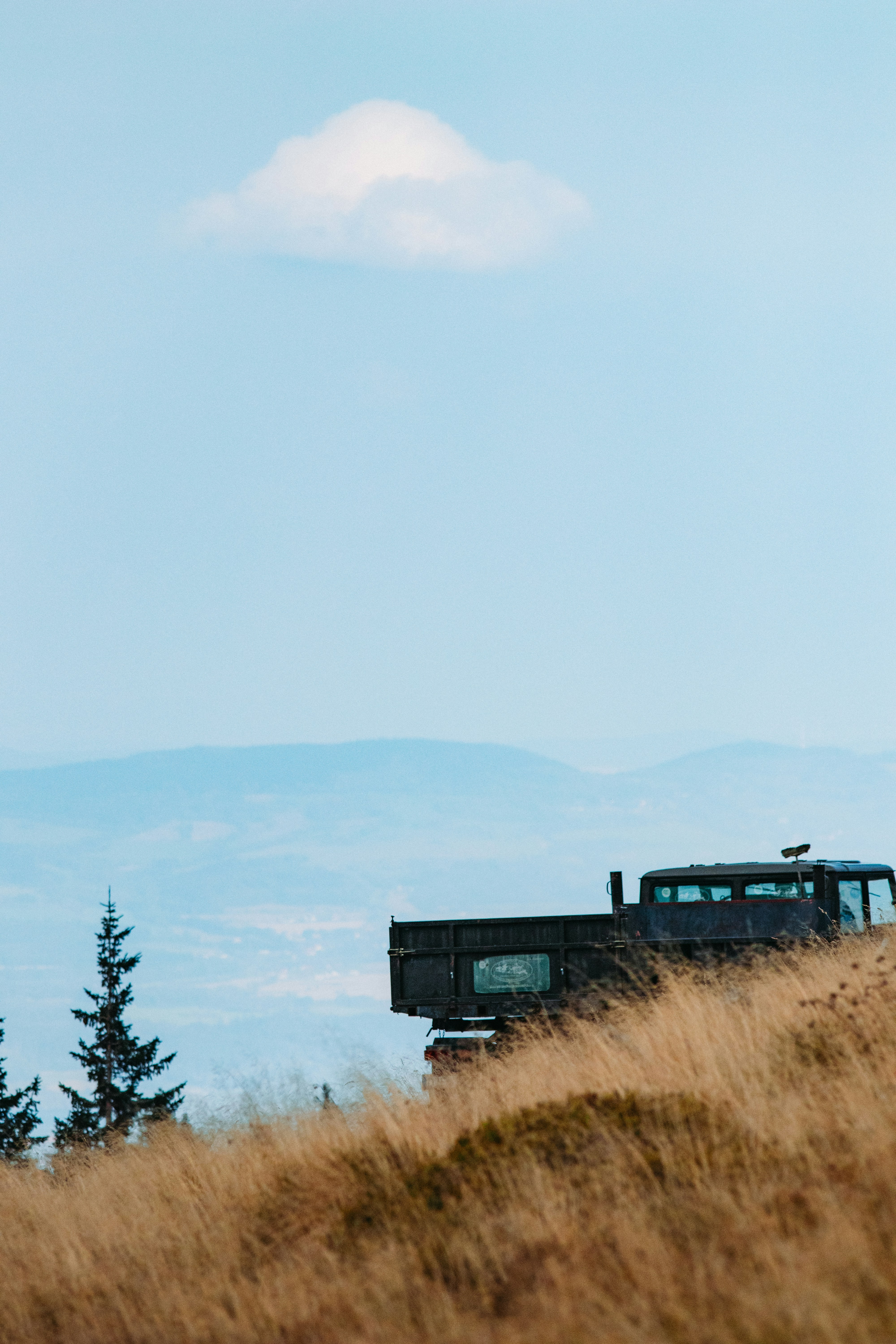 Rusted Truck on a Grassy Slope Beneath a Quiet Sky
