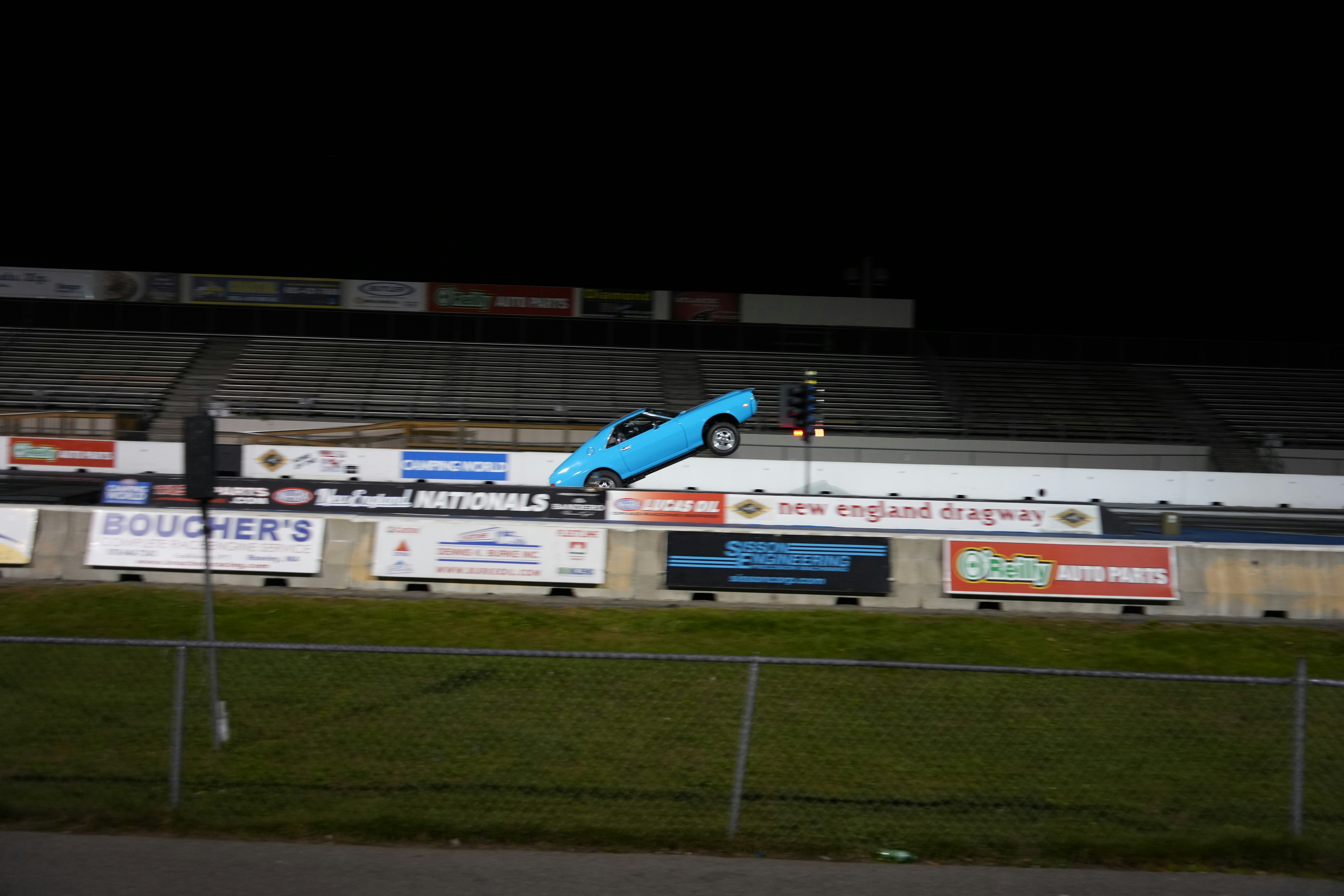 Midair Blue Pro Dragster Under Night Lights on a Quiet Raceway