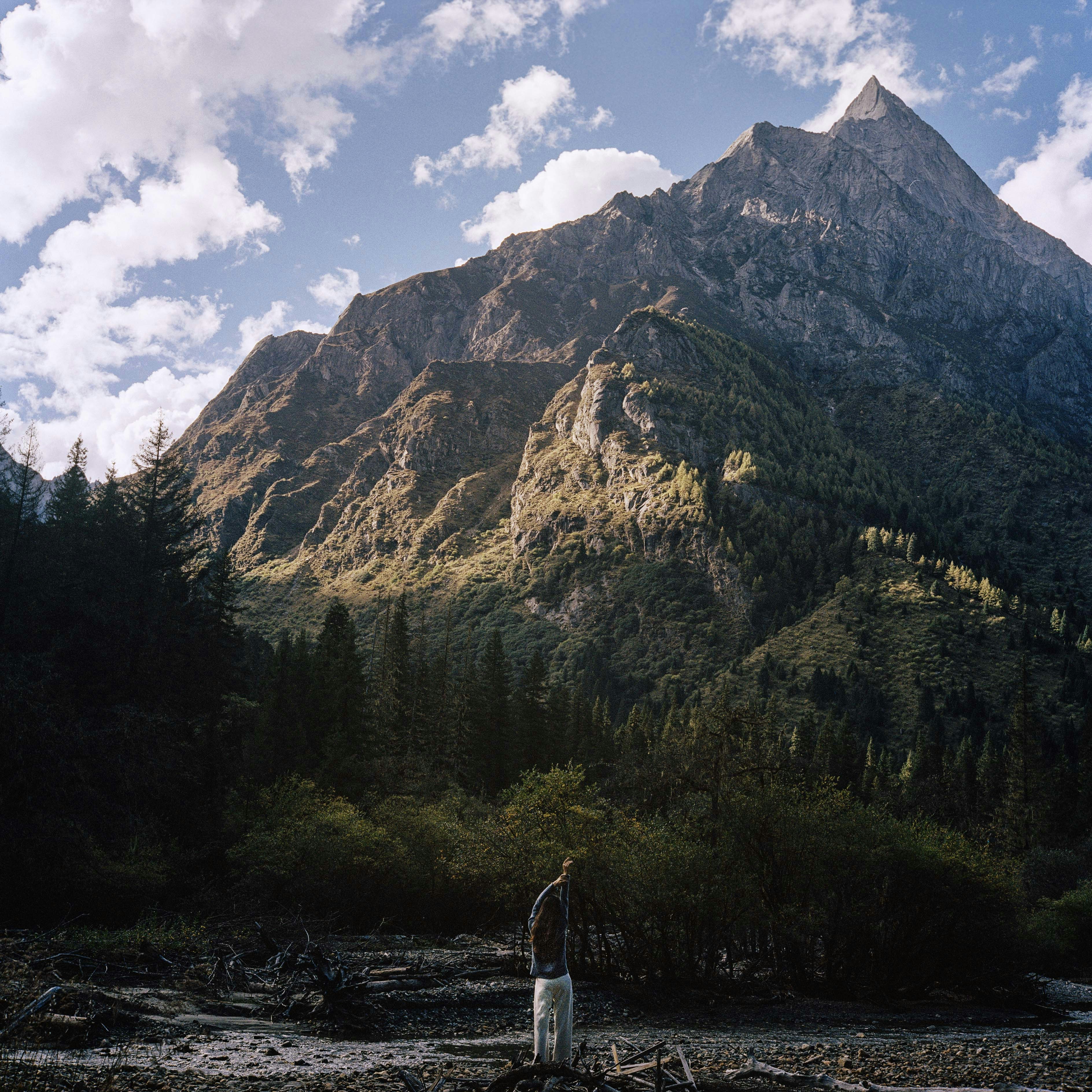 Ridge of Silence: A Lone Hiker Before the Mountain Tower