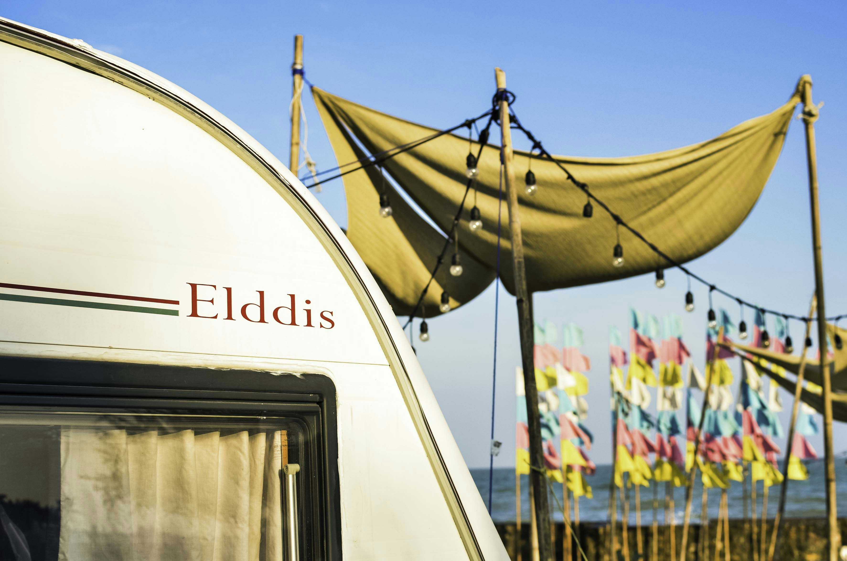 Elddis Caravan at a sunny seaside setup with colorful pennants