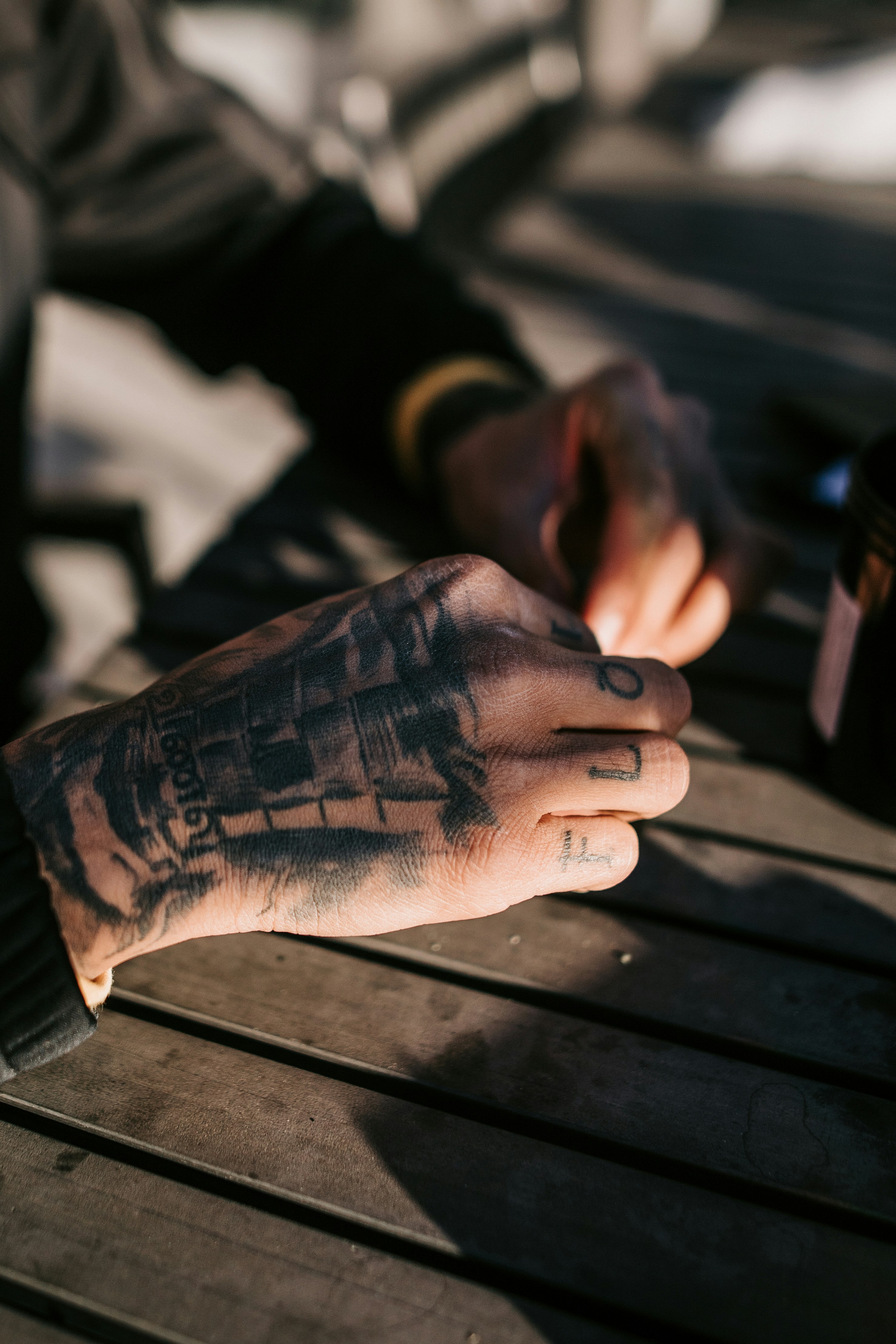 A person with a tattoo on their arm sitting on a bench photo – Free ...