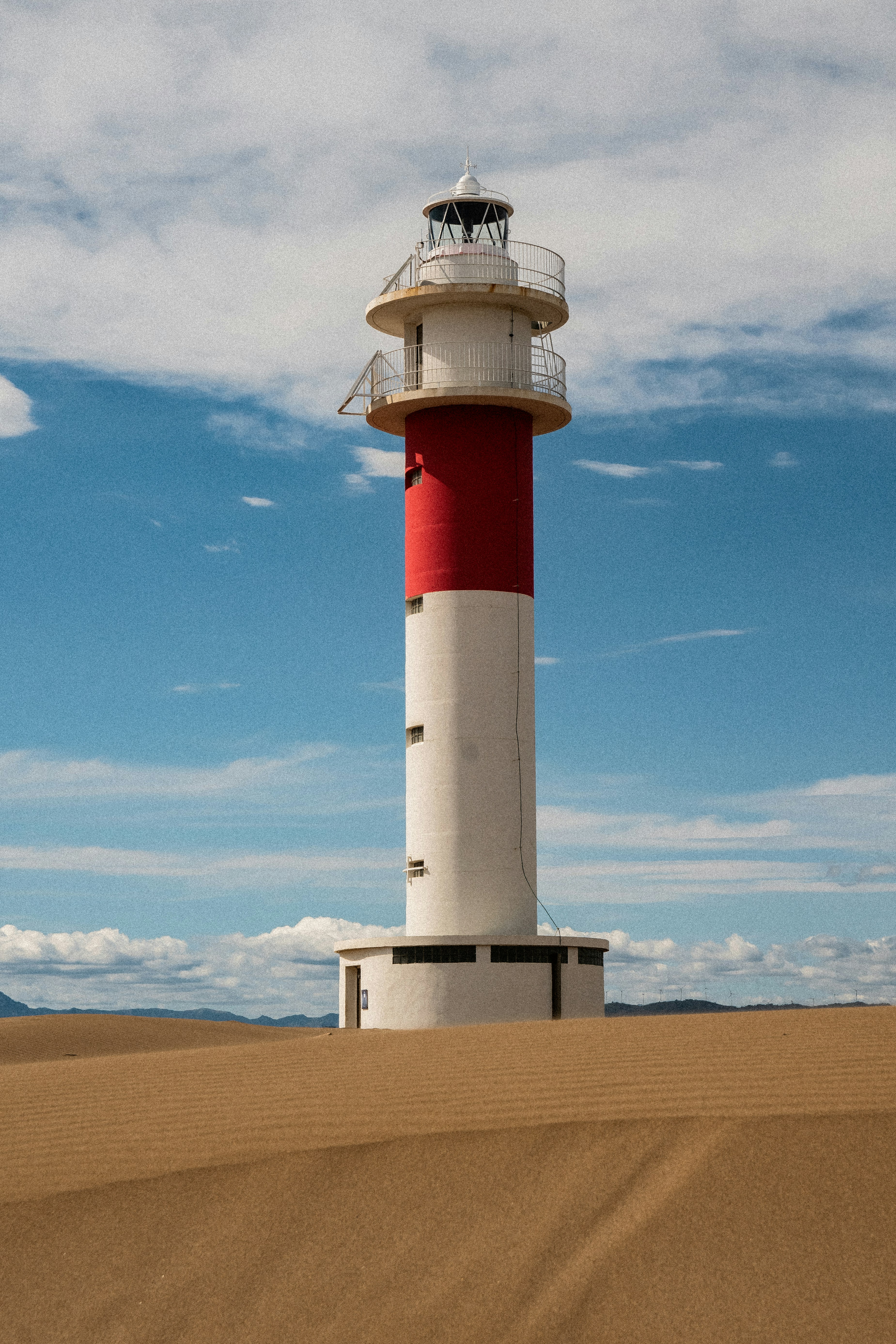 A red and white lighthouse in the middle of a desert photo – Free ...