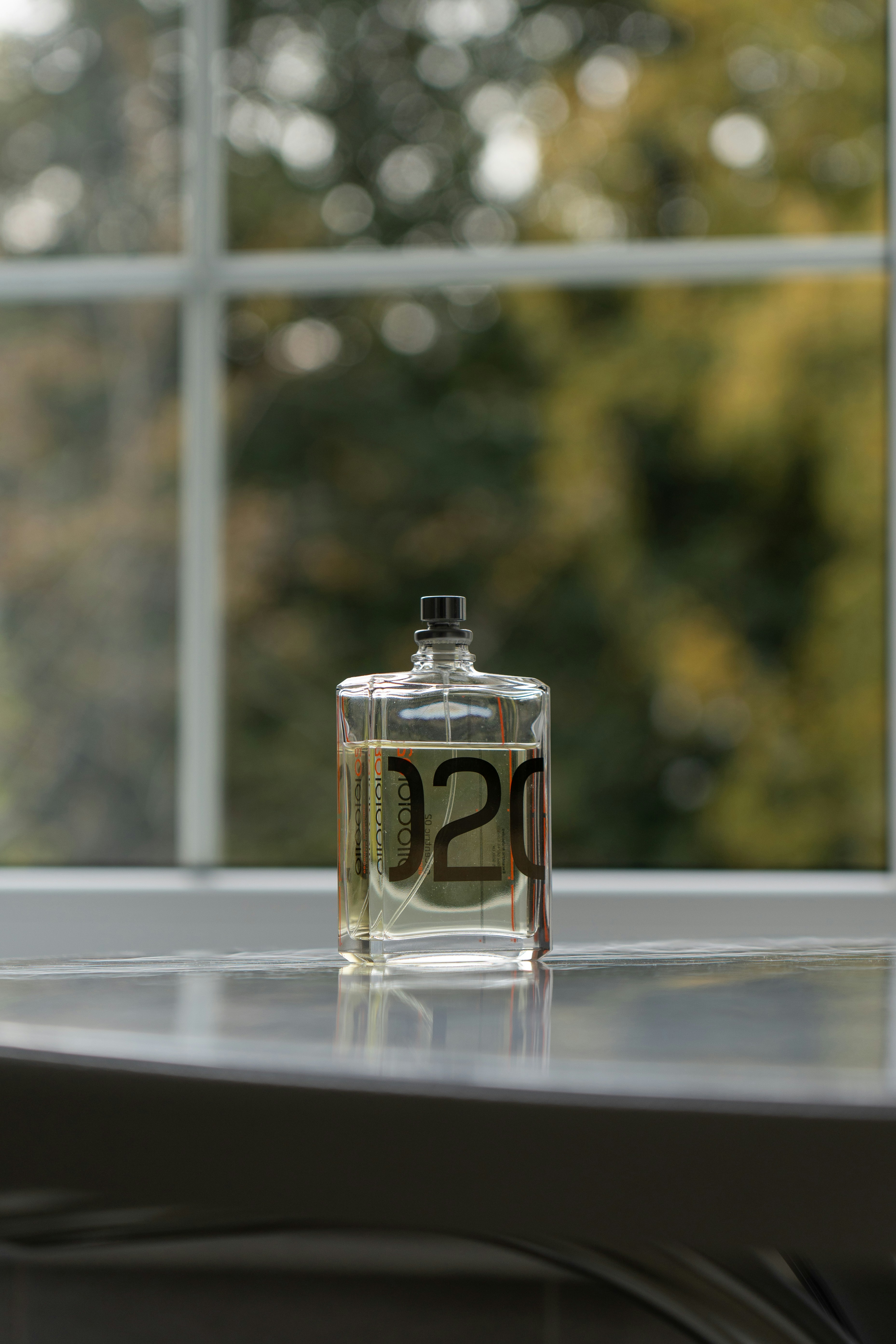 Numeral in Glass: A Minimal Perfume Bottle on a Sunlit Window