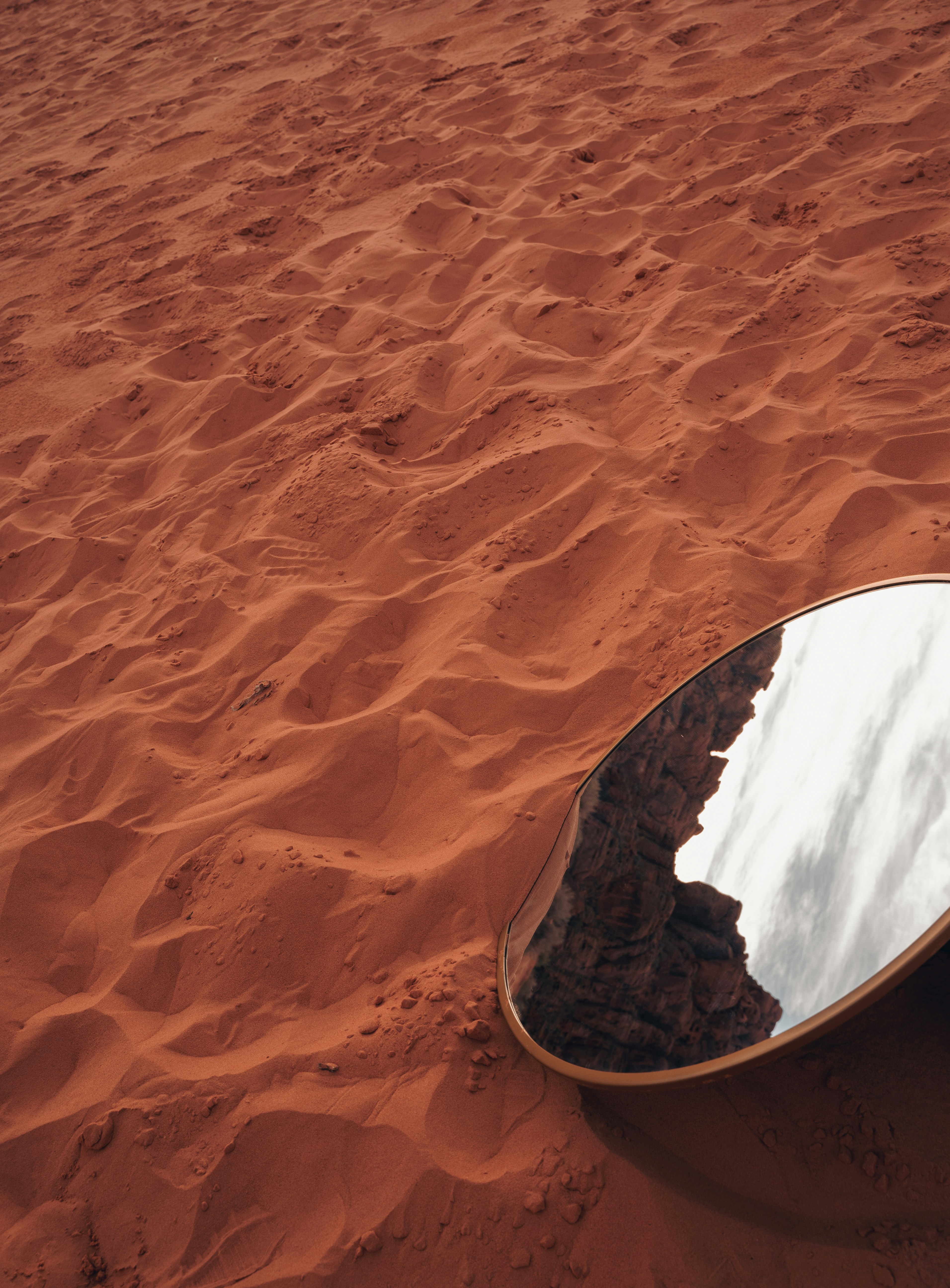 Echo in the Red Dunes: A Circular Mirror Reflects Sky and Cliff