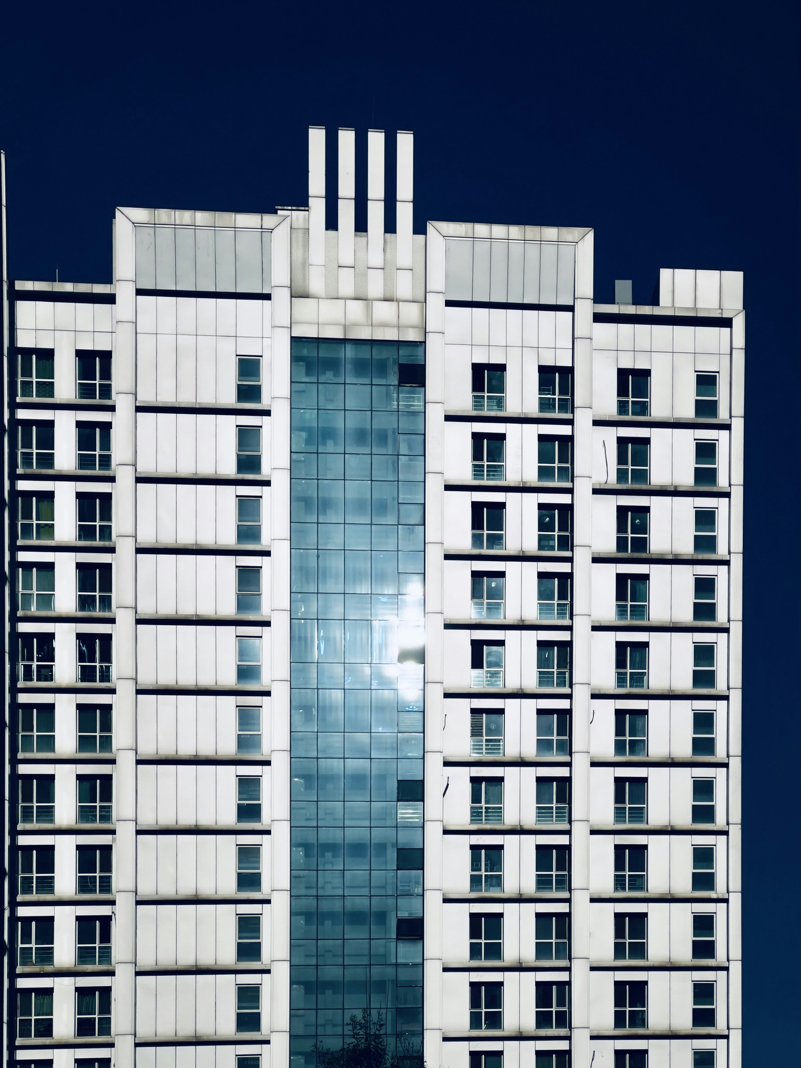 Symmetric Glass Tower Against a Deep Blue Sky