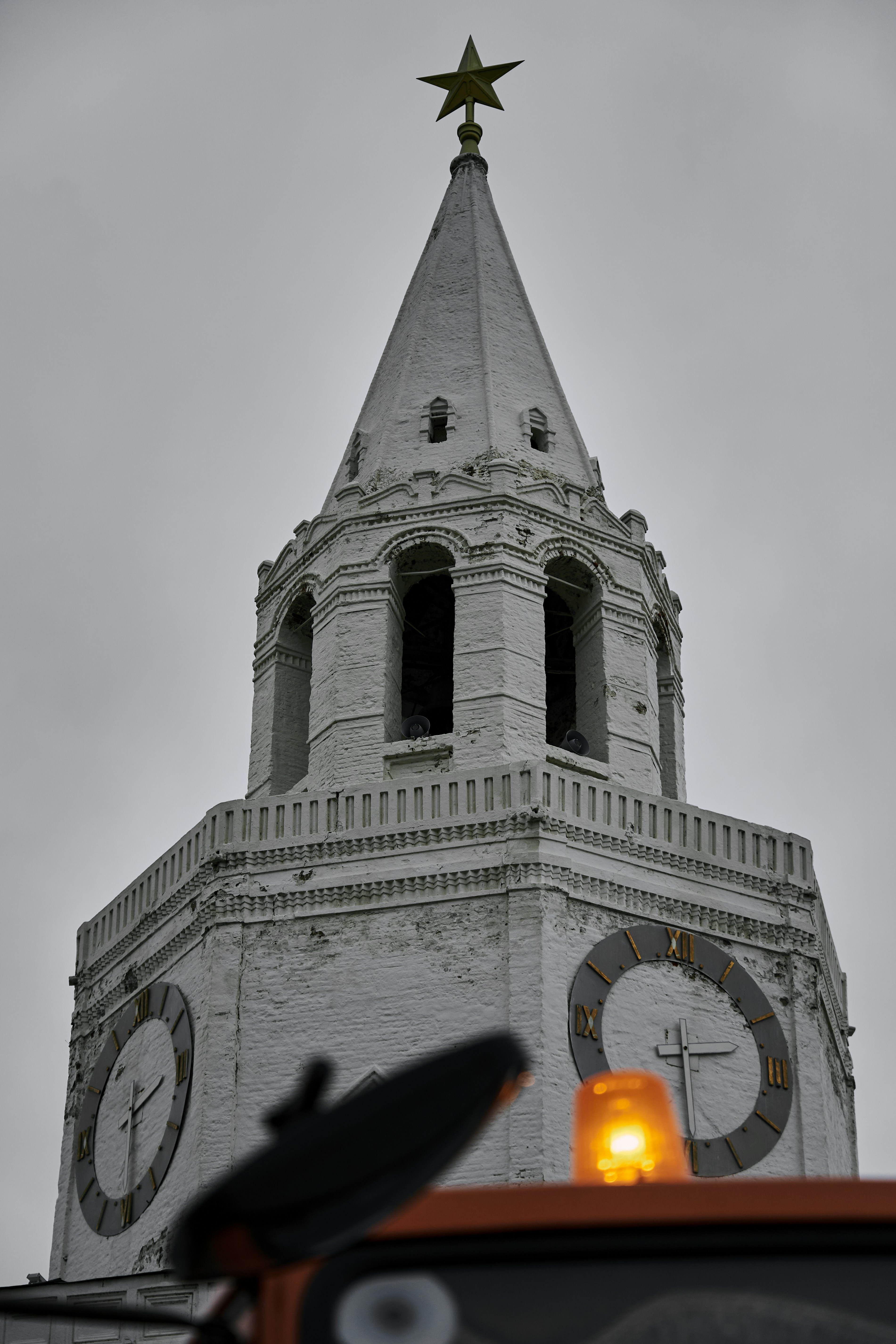 Towering Clock with Orange Beacon: A Silent Monument Under Gray Skies