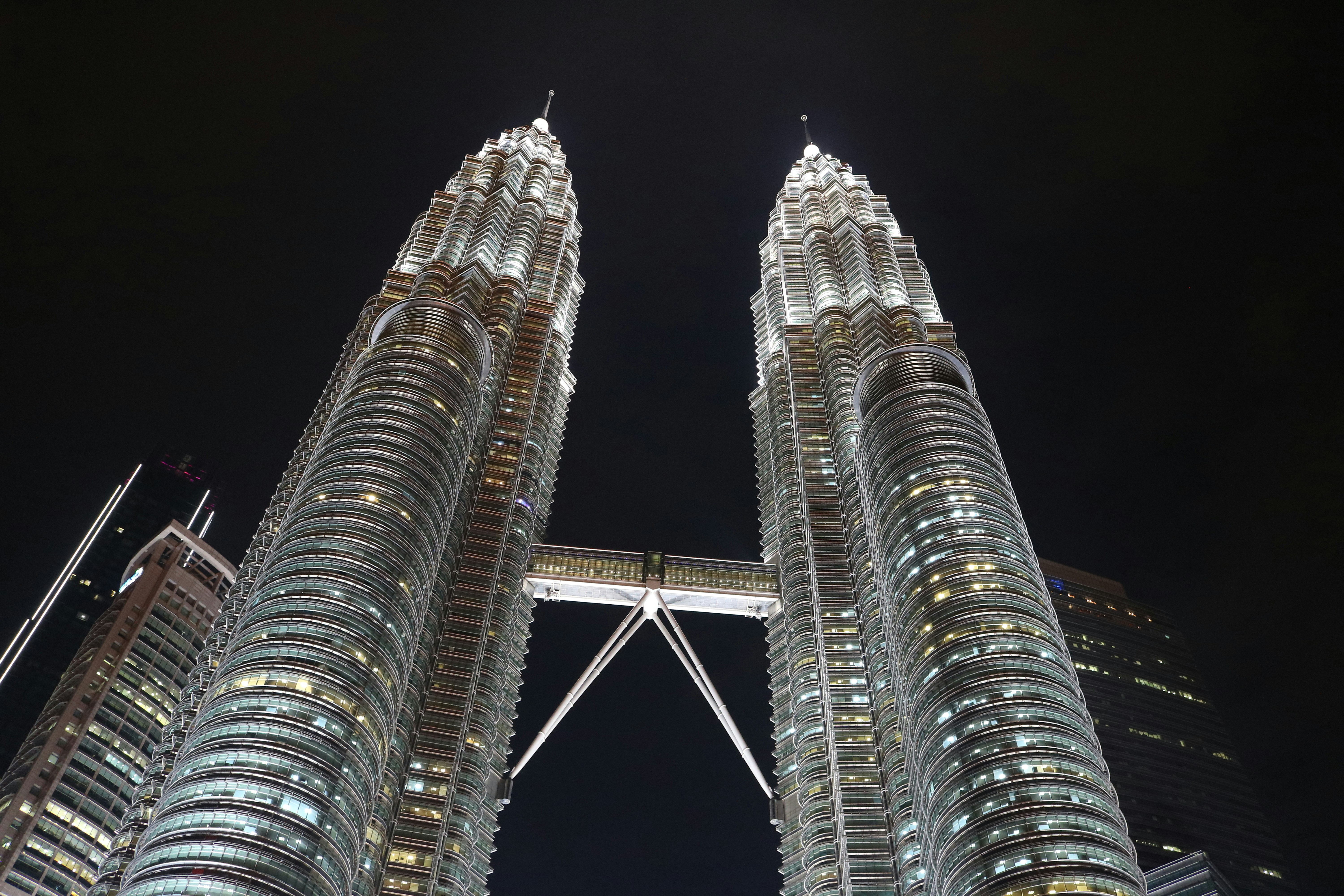 Two very tall buildings towering over a city at night photo – Free ...