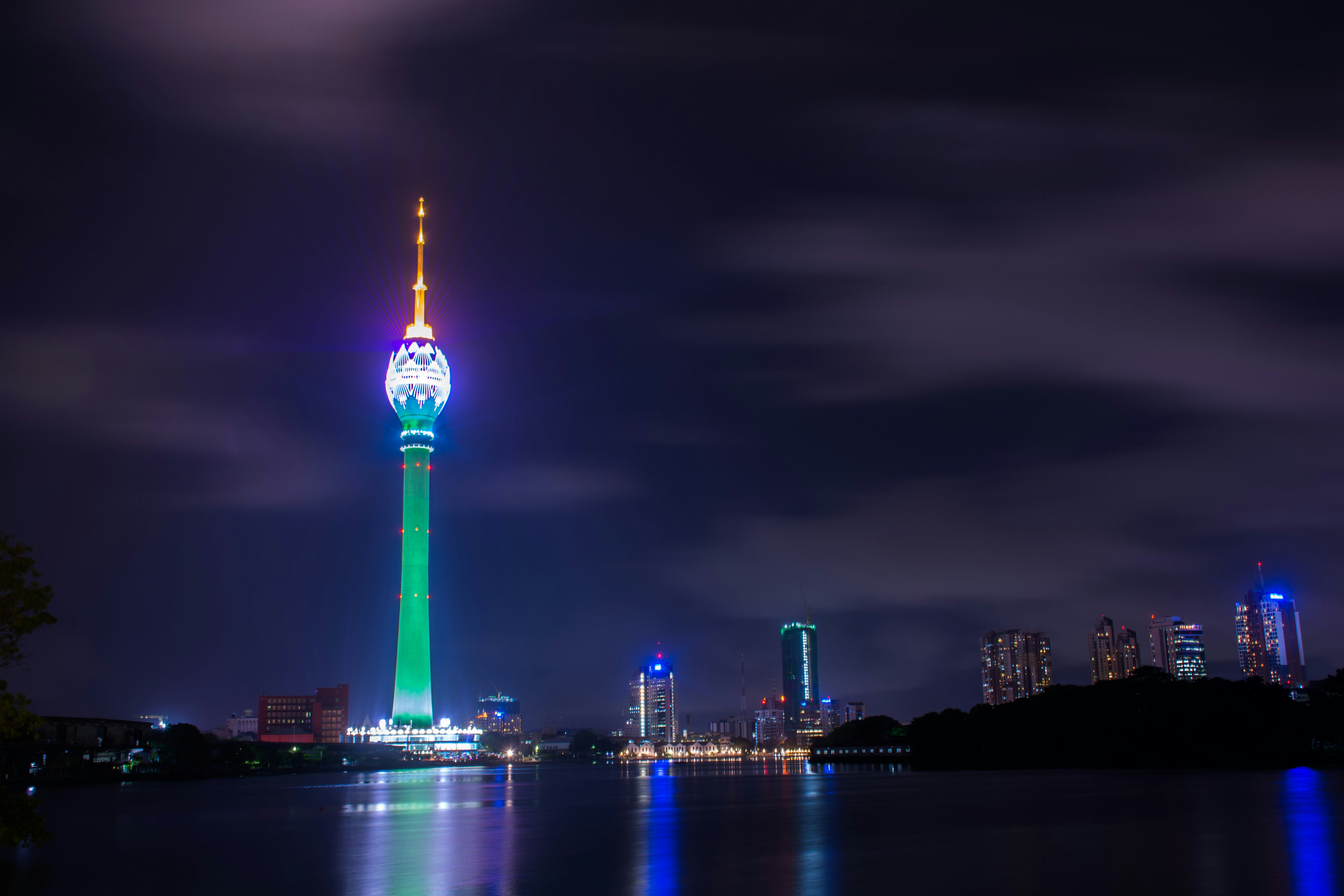 Emerald Spire Over a Quiet River at Night