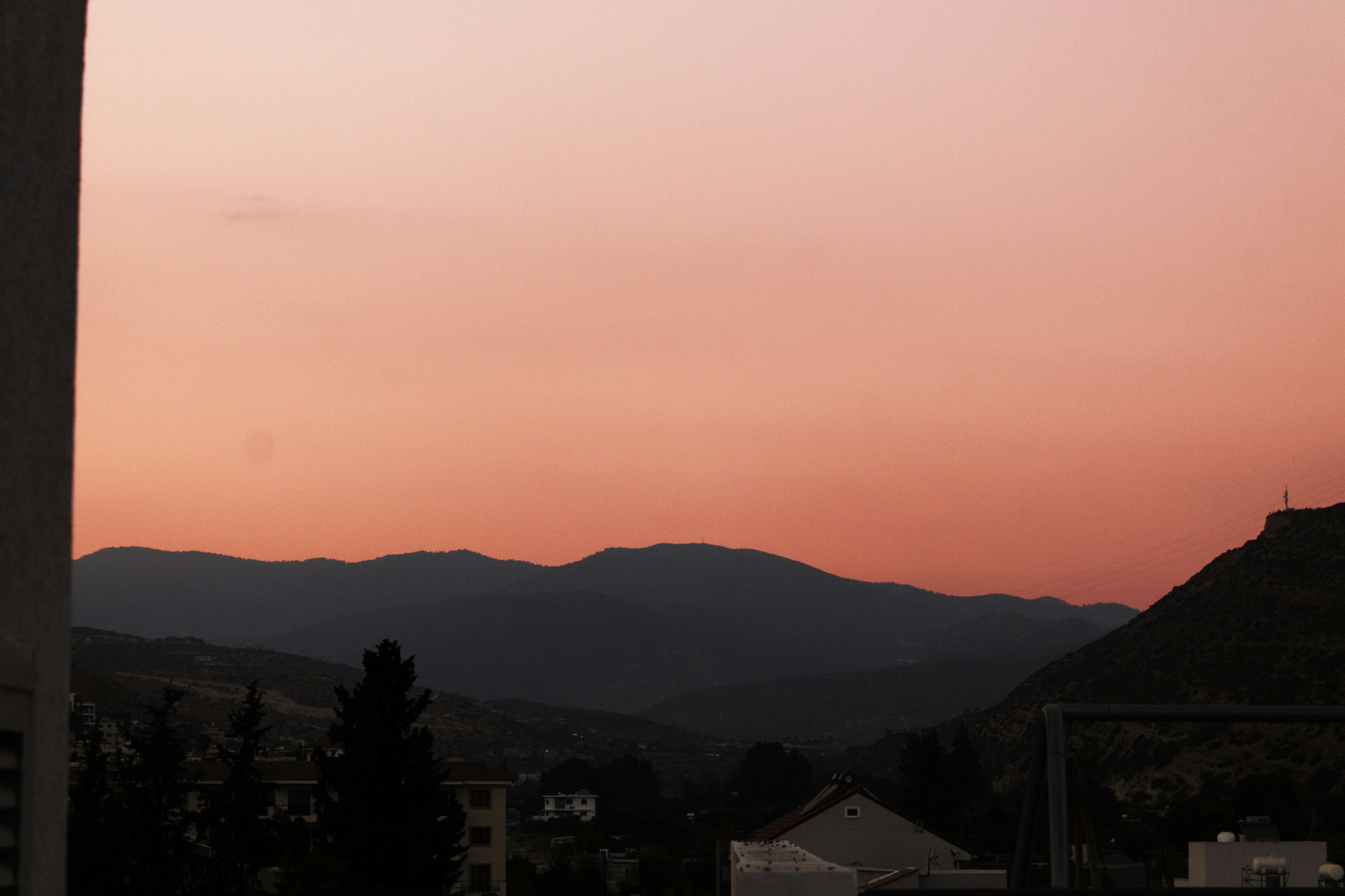 Soft pink and purple hues blend across the sky as mountains silhouette against the twilight, capturing the serene transition from day to night.