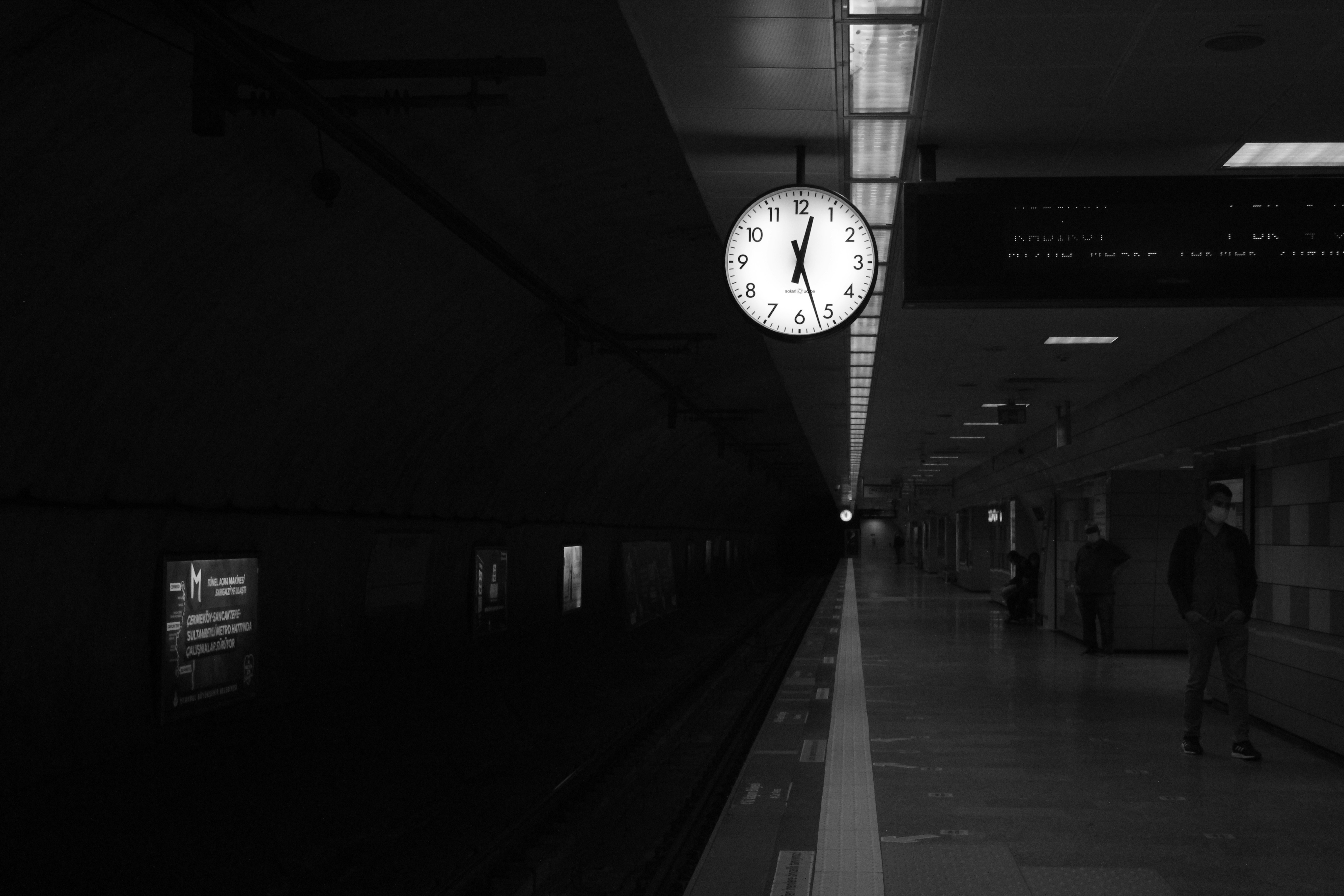 Central Clock Over Tracks: A Quiet Monochrome Subway Platform