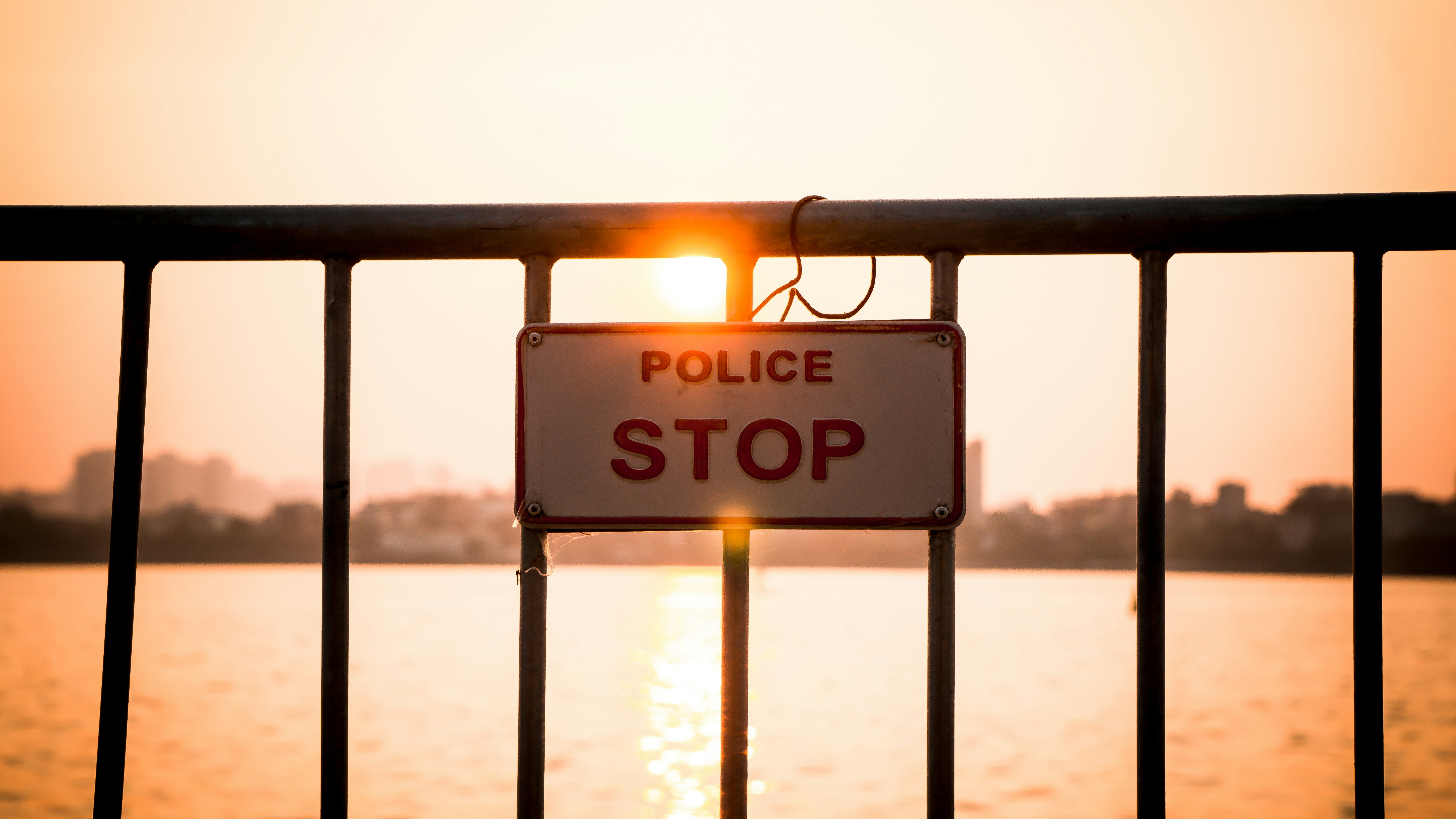 A police sign is posted on a gate overlooking a body of water photo ...