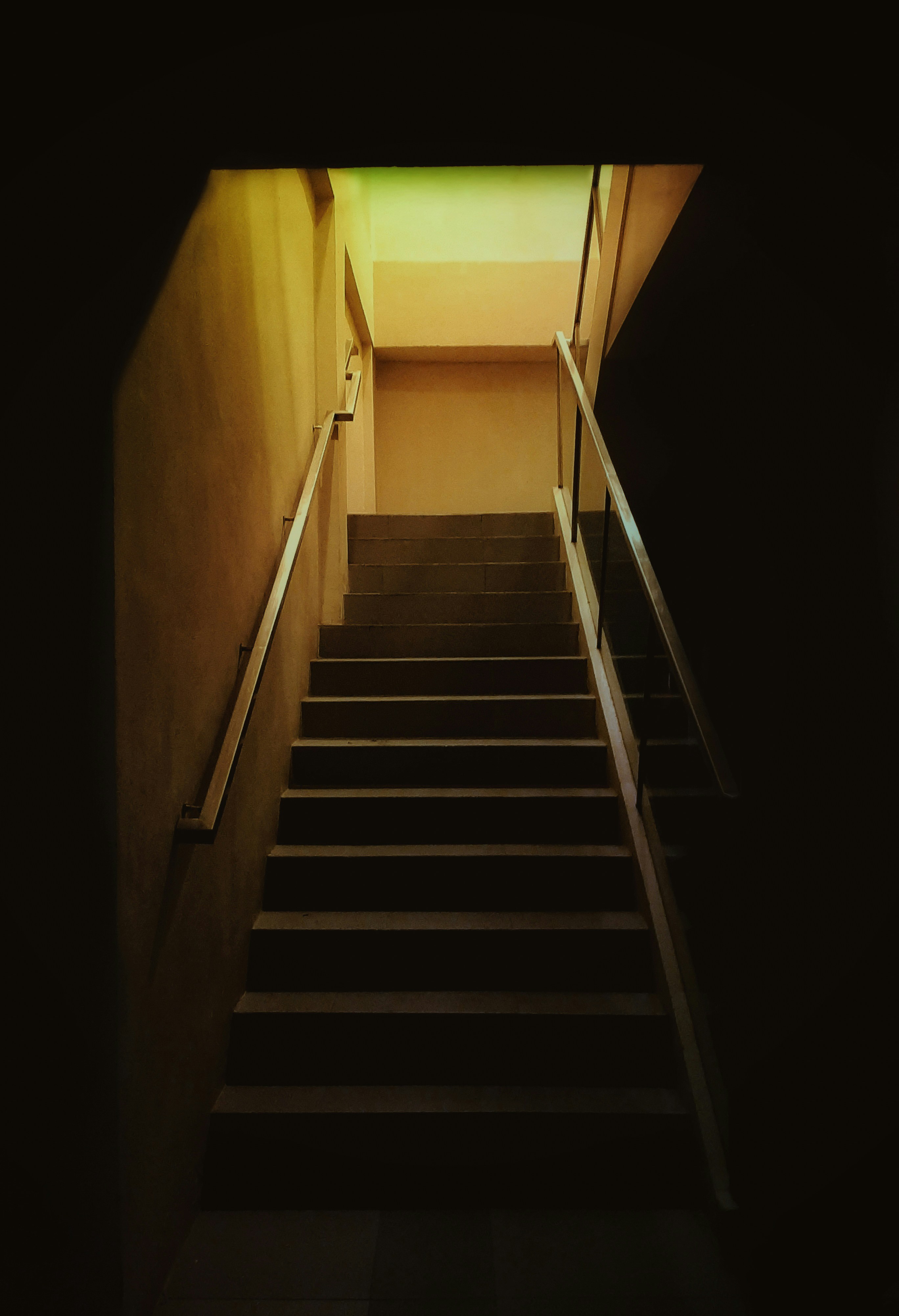 Dimly lit staircase leading to an illuminated doorway, creating a sense of mystery and anticipation.