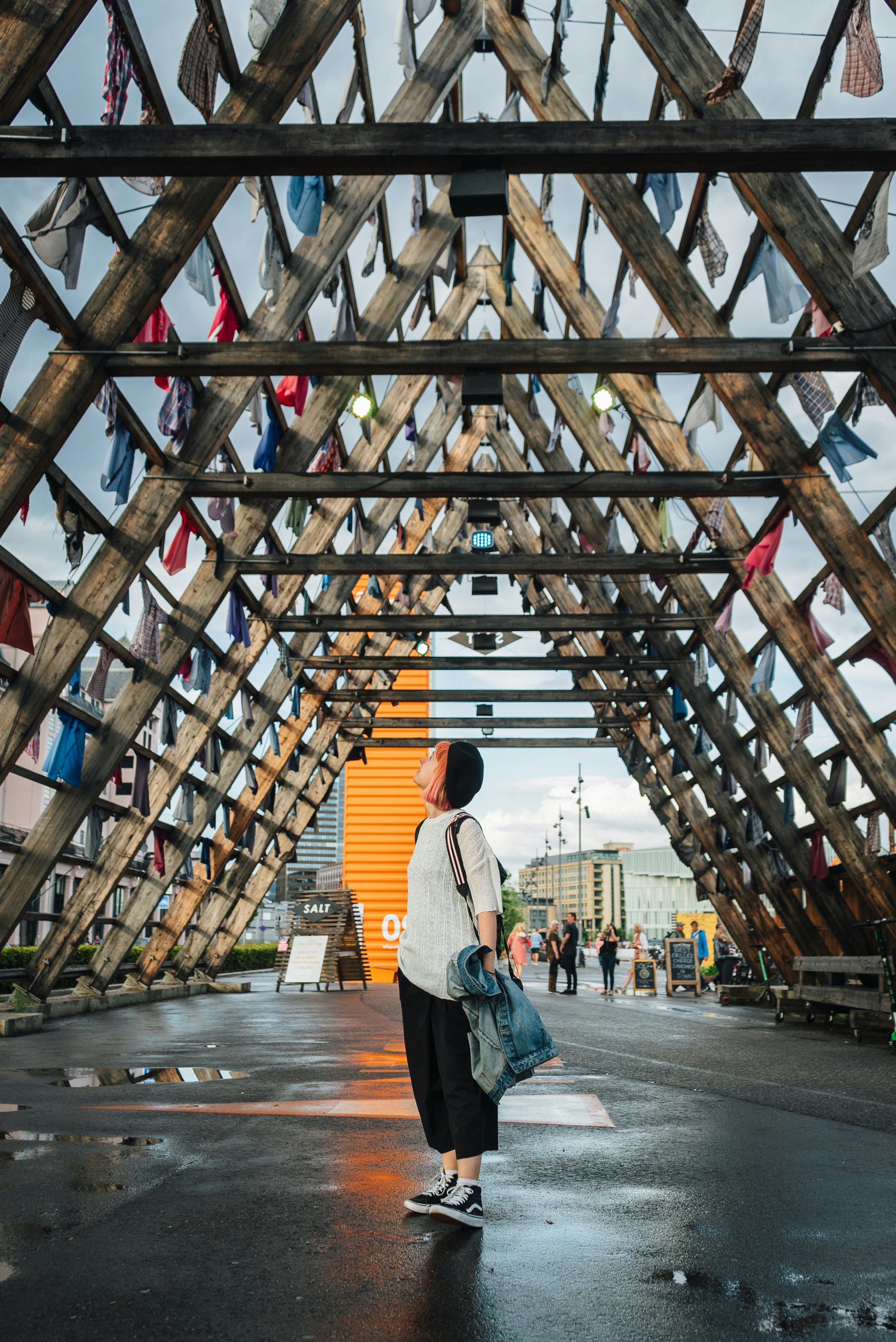 Timber Cathedral Arch Under Colored Ribbons: A Figure Gazes Toward the Sky