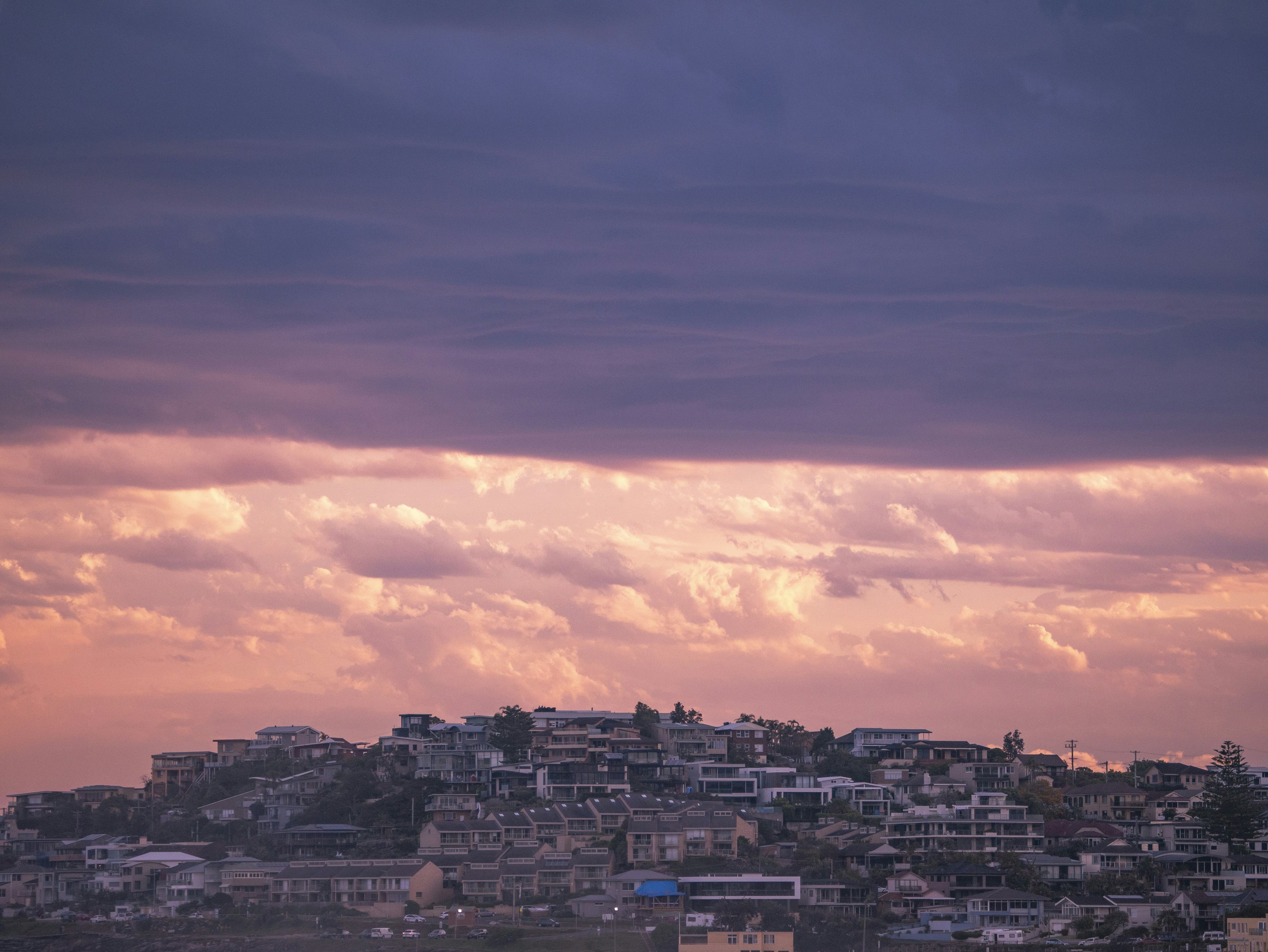 Pastel Horizon Over a Terraced Hillside City at Dusk